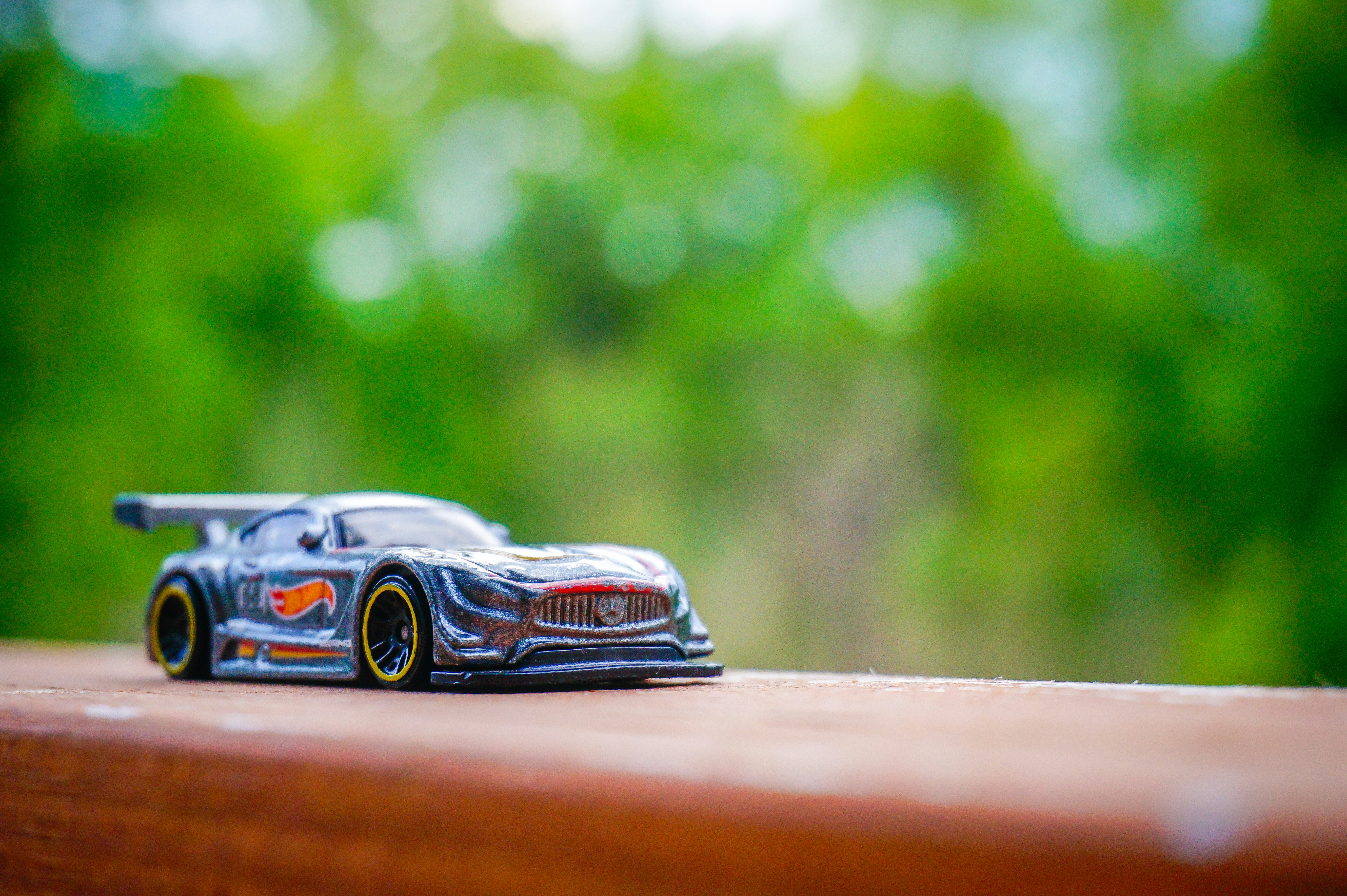 Mini Trophy Car on a Wooden Track: A Blur of Green Behind