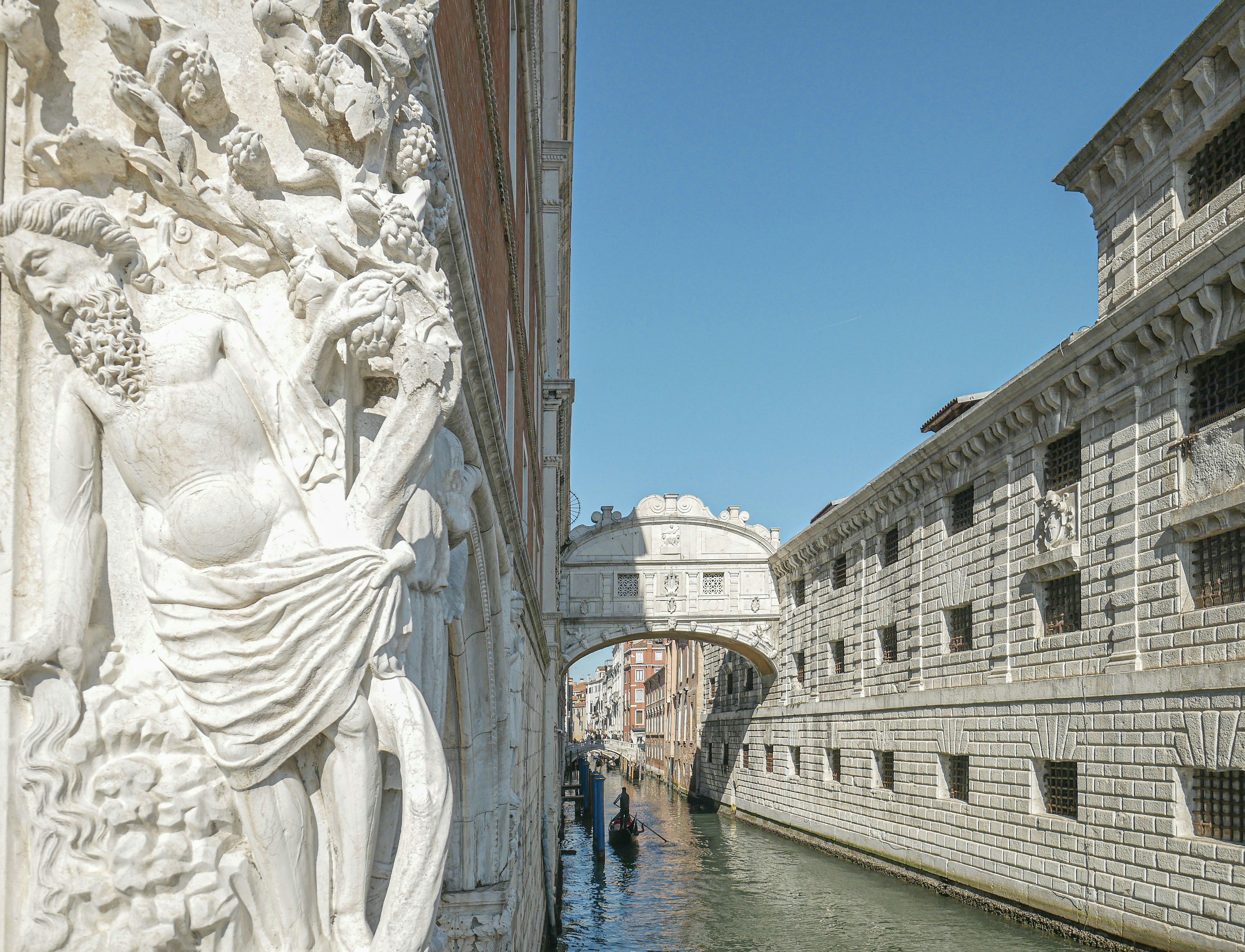 Stone Archways and Canal: Architecture Framed by a Carved Wing