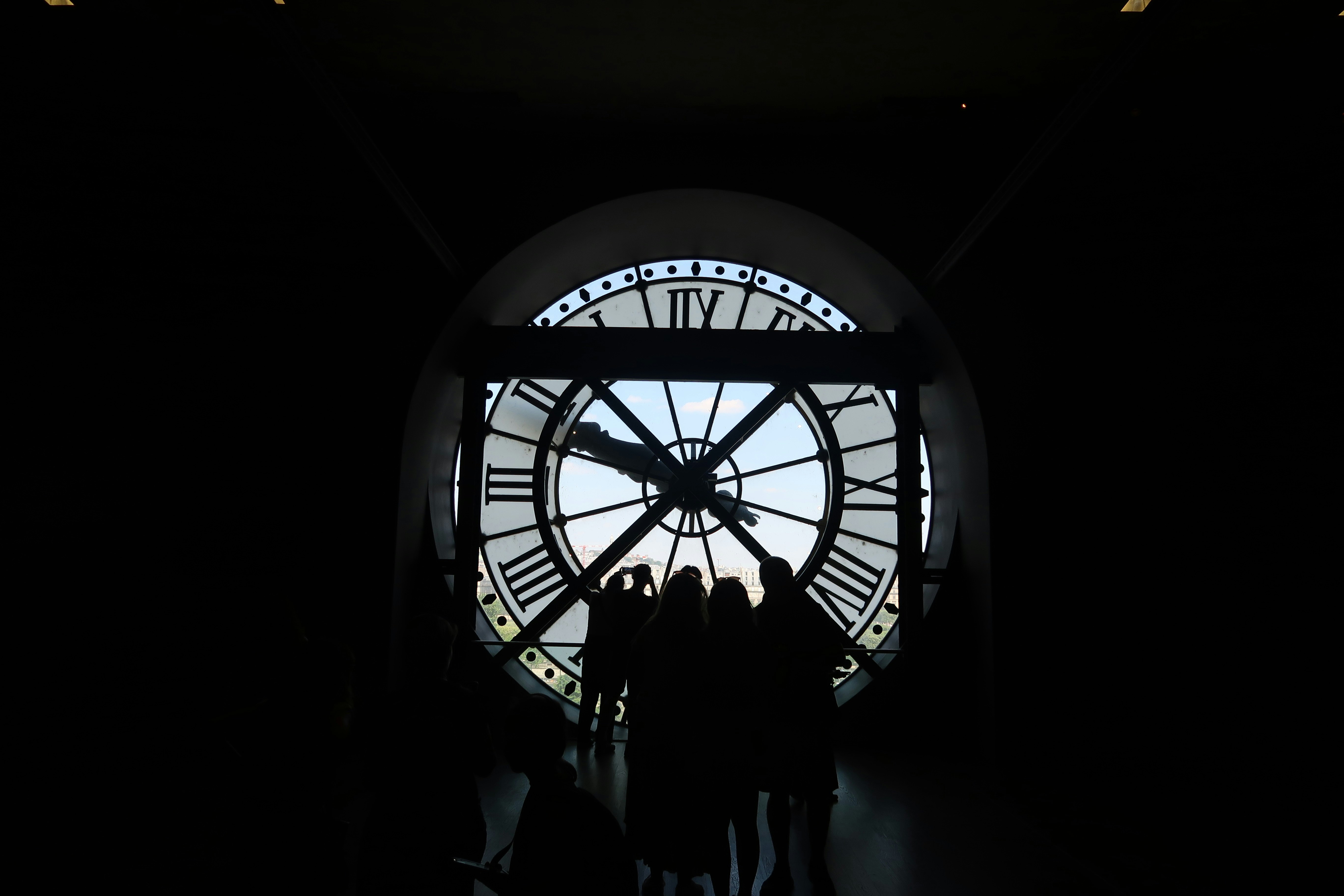 Timeless Gears: People Silhouetted Before a Clock Face