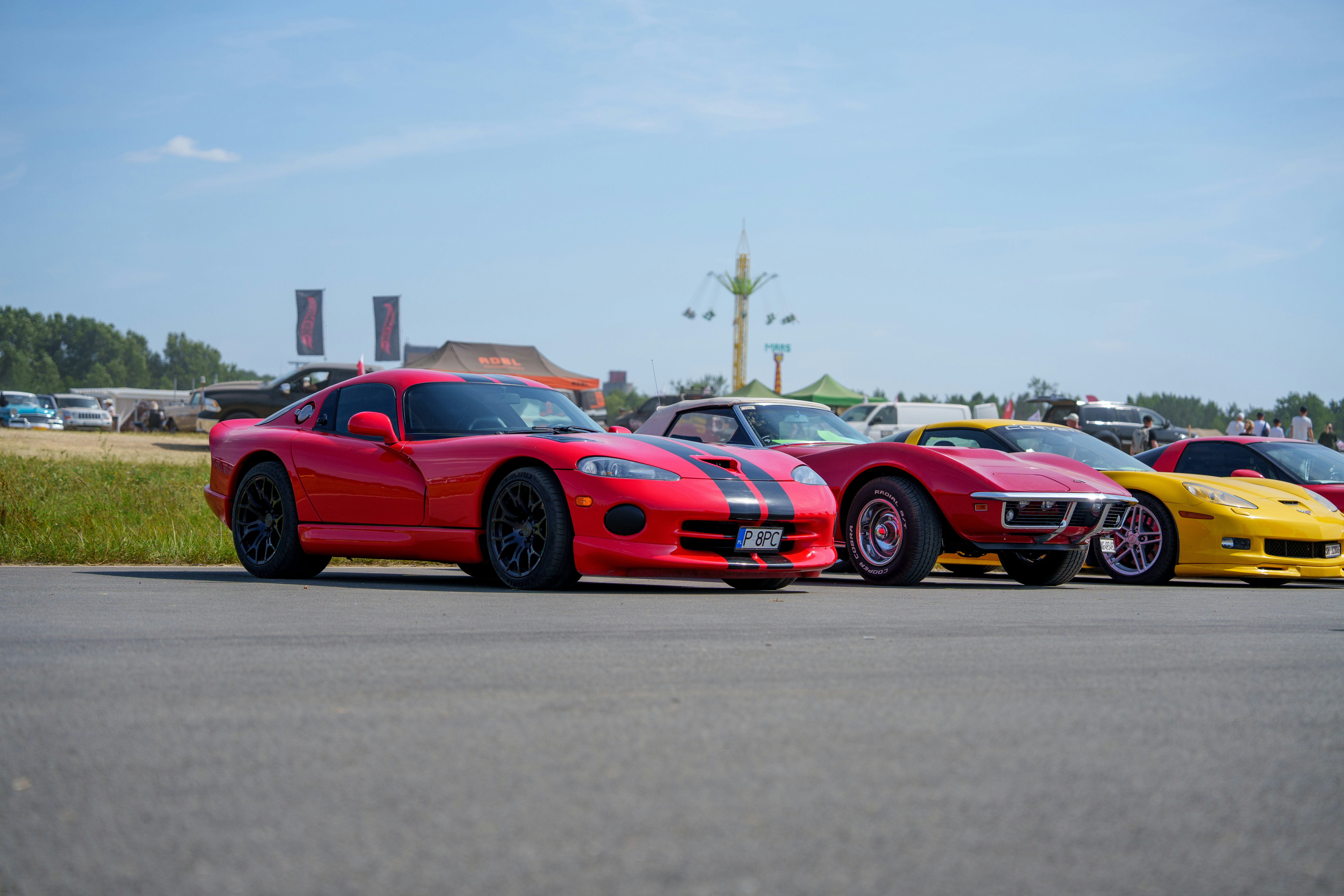 Red Vipers at the Sunlit Strip: A Row of Sportscars in Focus