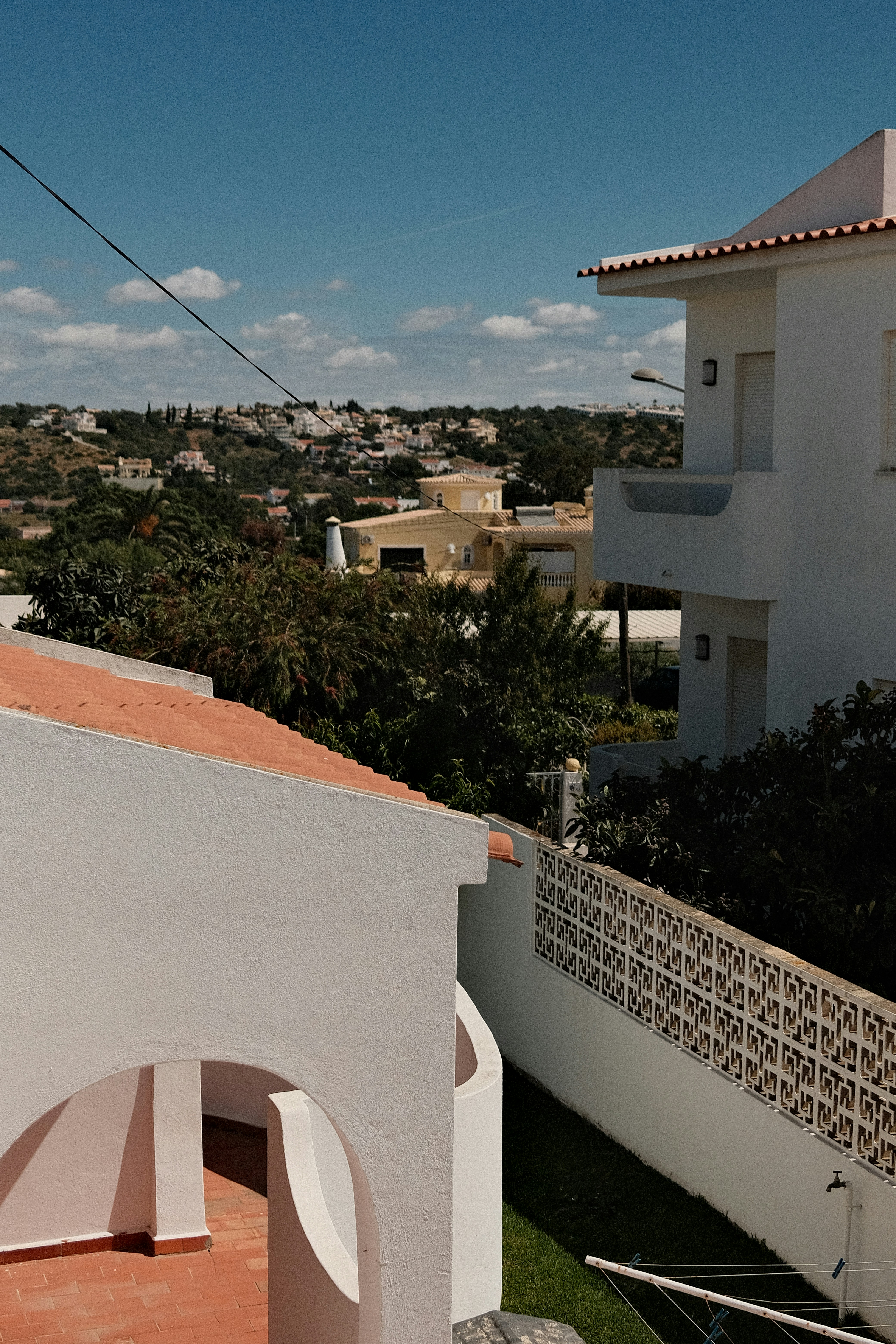 White buildings with red tile roofs overlooking a town.