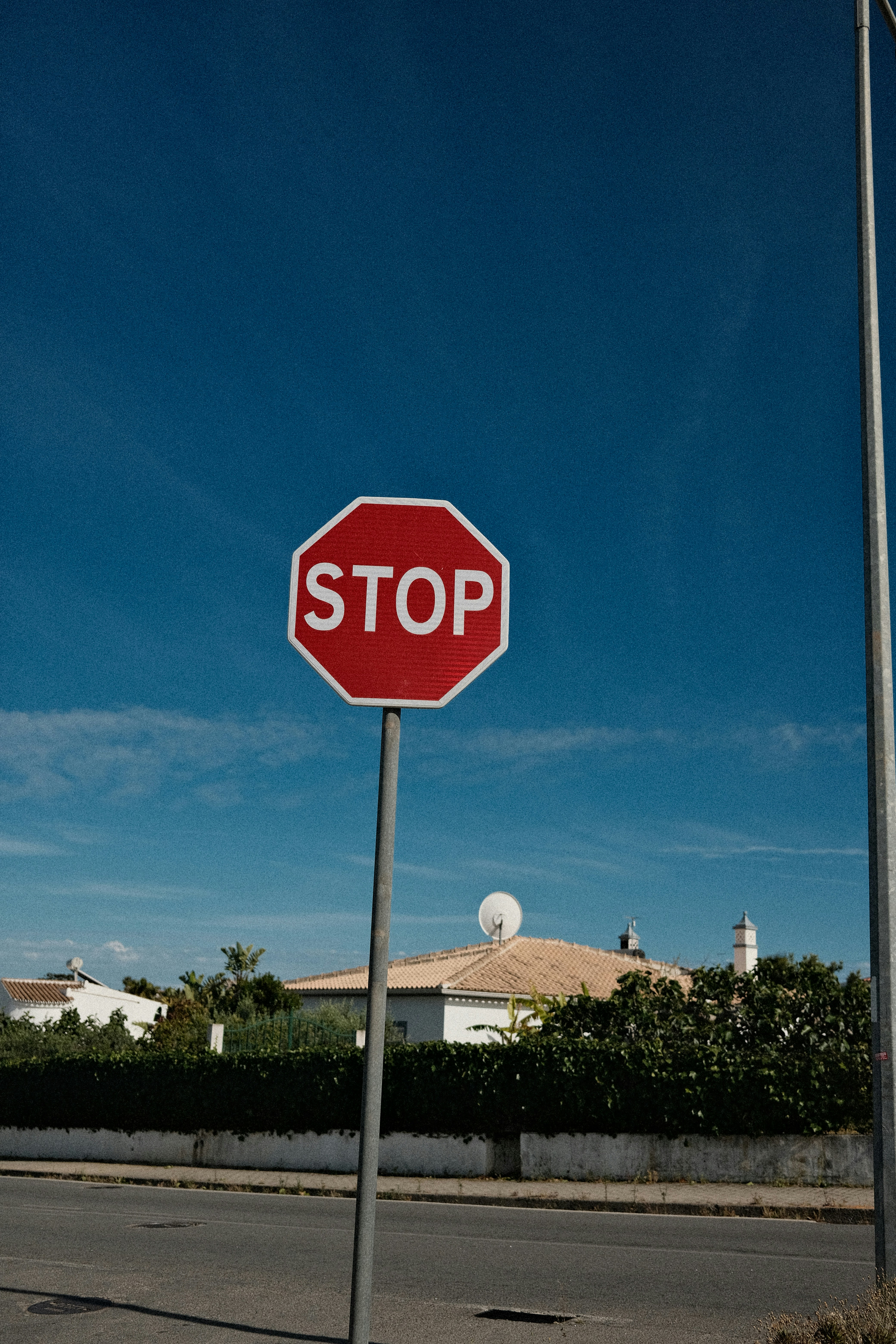 Stop Sign Under a Clear Blue Sky Over Suburban Street