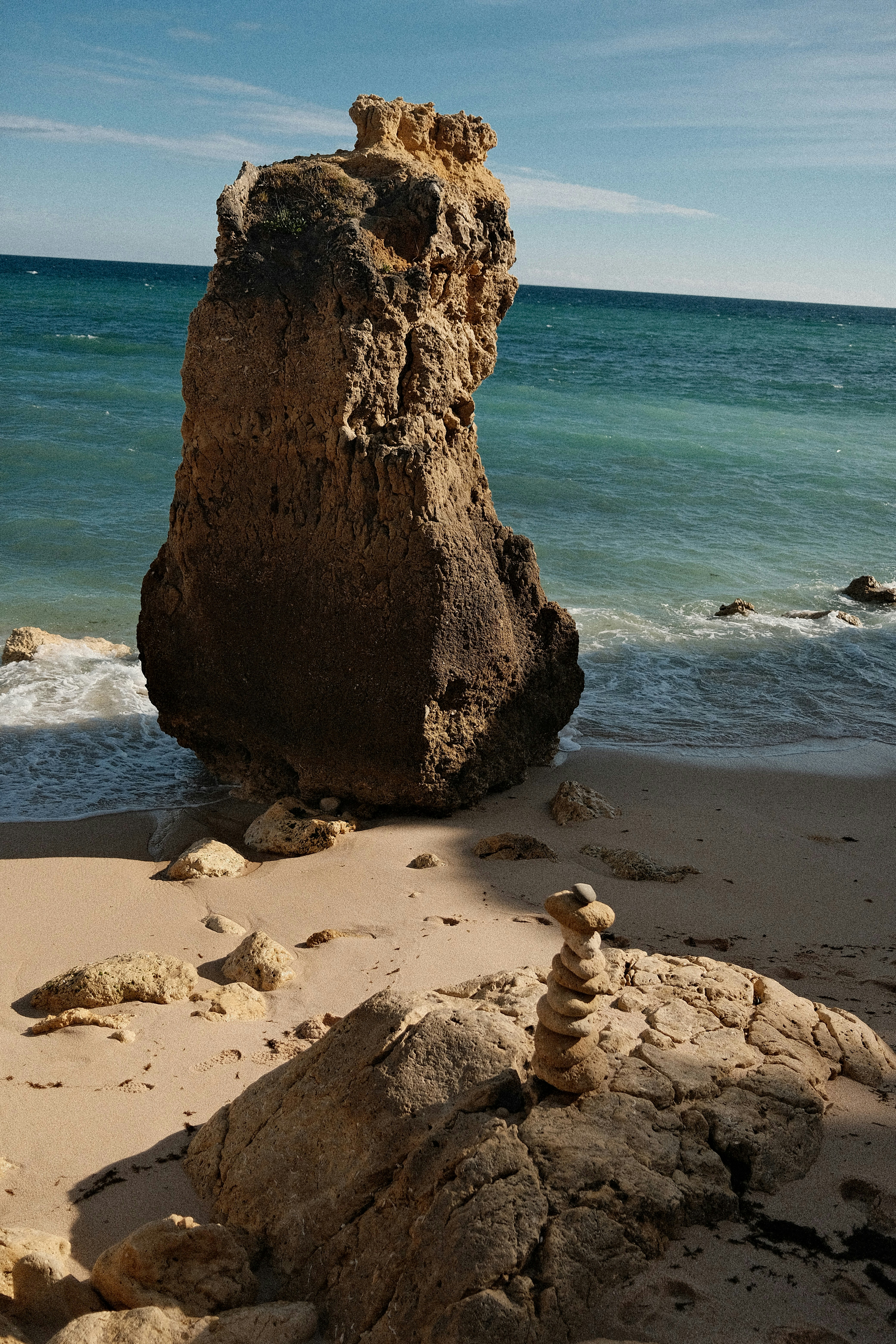 Sea-stone sentry: a weathered rock guarding a quiet shoreline