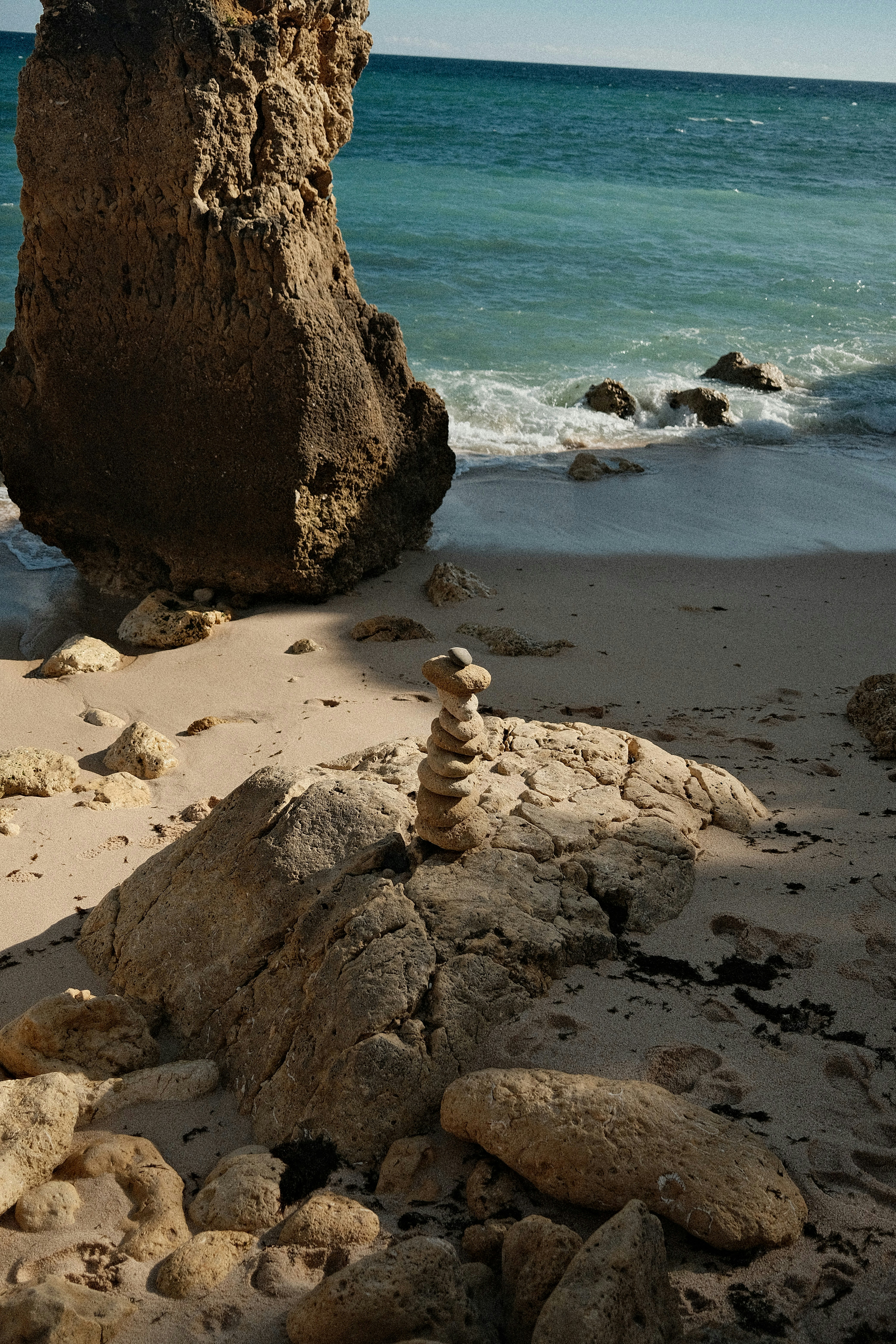 Stone Balance at the Edge: A Seaside Stack On a Sunny Shore