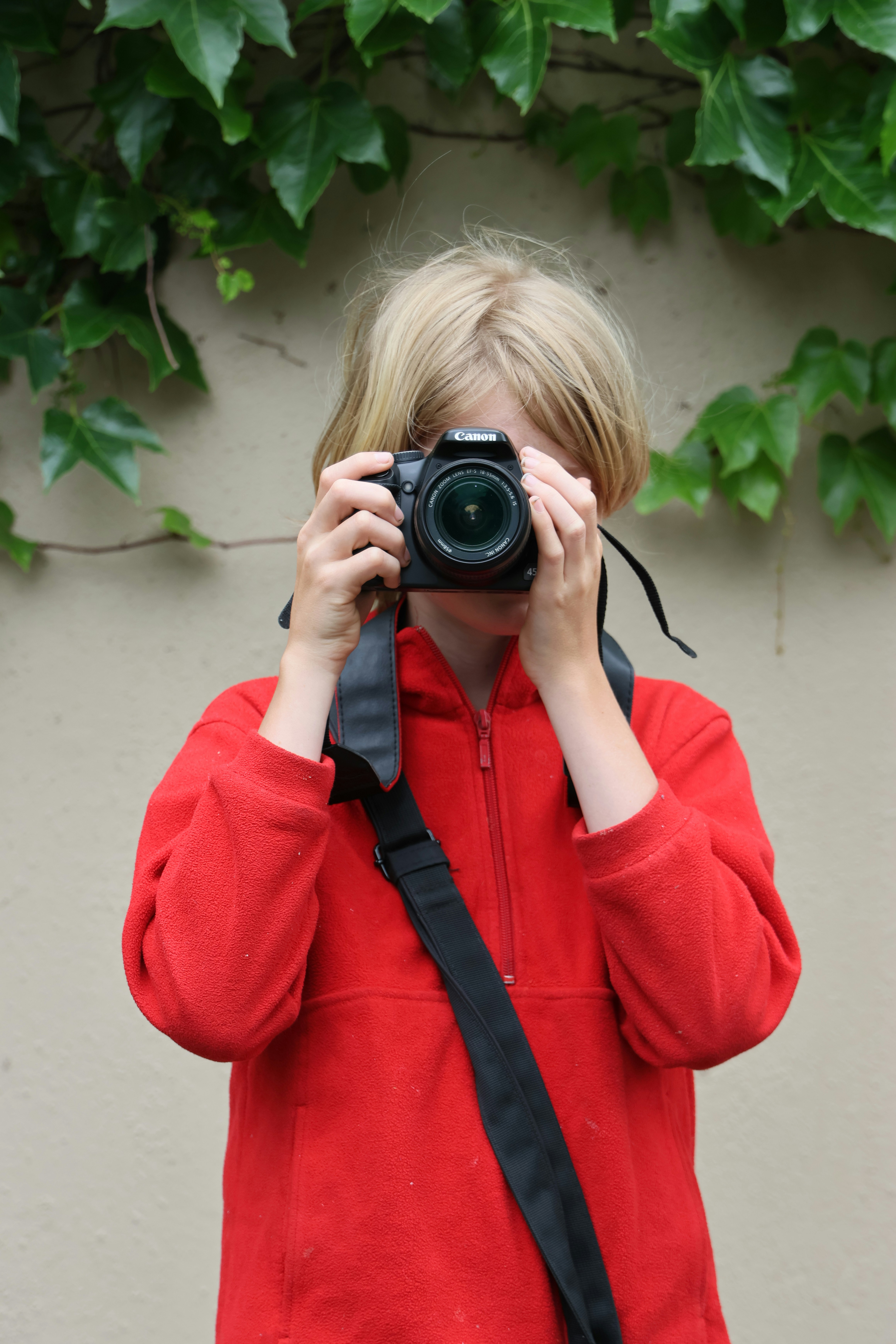 Focused Youth with Camera: A Red Hoodie Moment