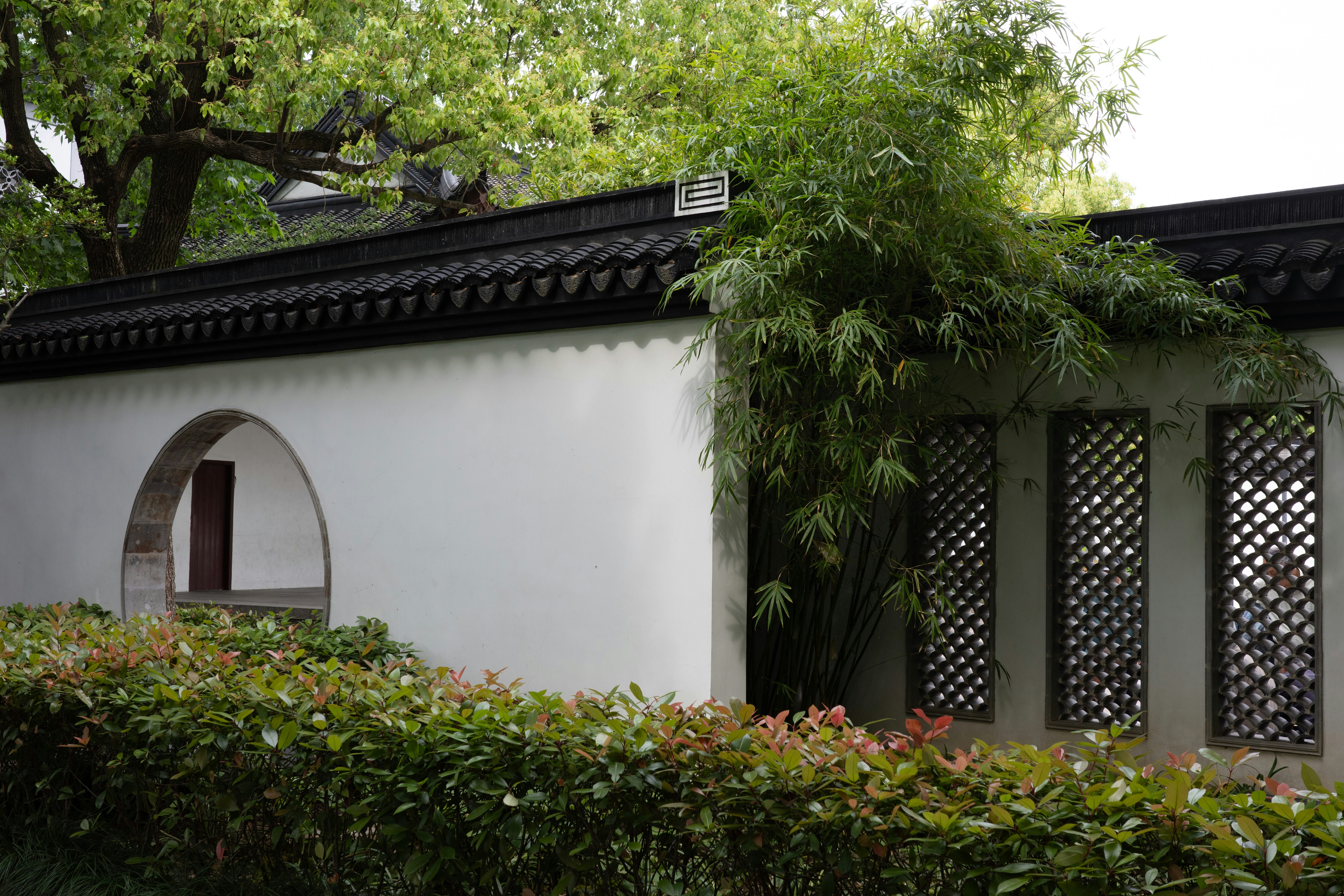 Quiet Courtyard Wall with Moon Window and Bamboo Shade