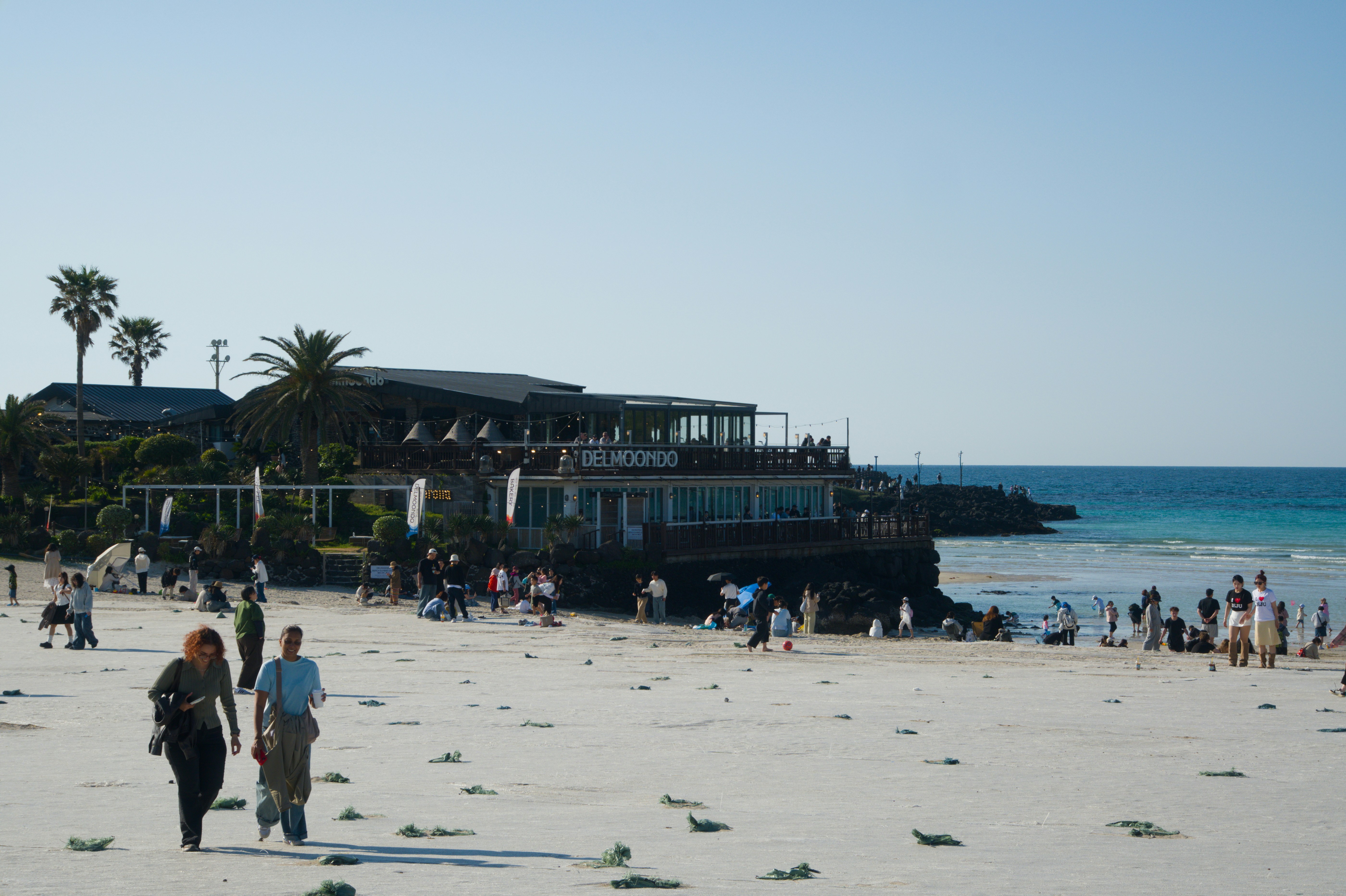 Beachfront Café at Dusk: People Strolling by a Seaside Restaurant