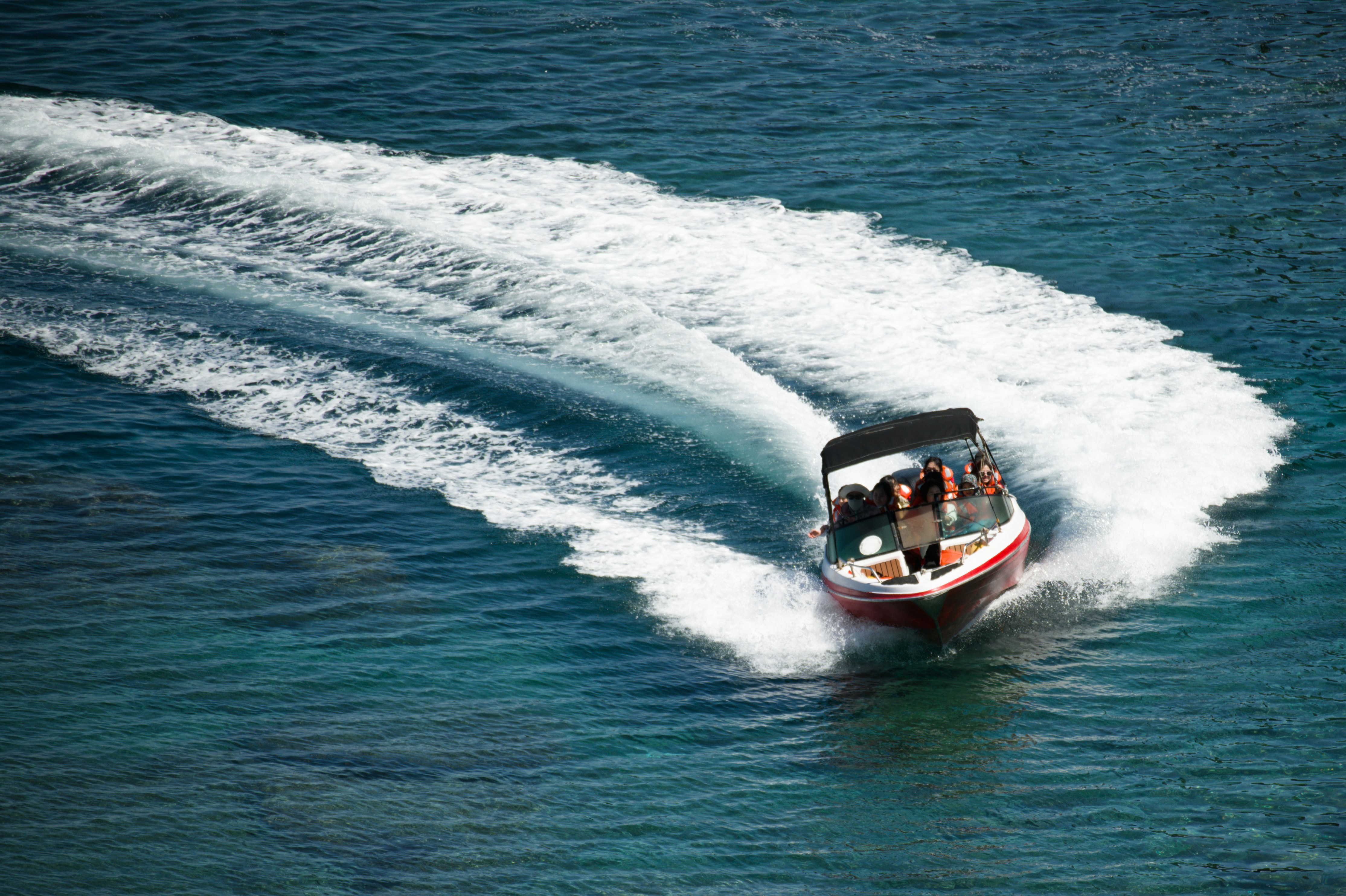 High-Speed Coastal Escape: A Red Boat Carves a White Wake