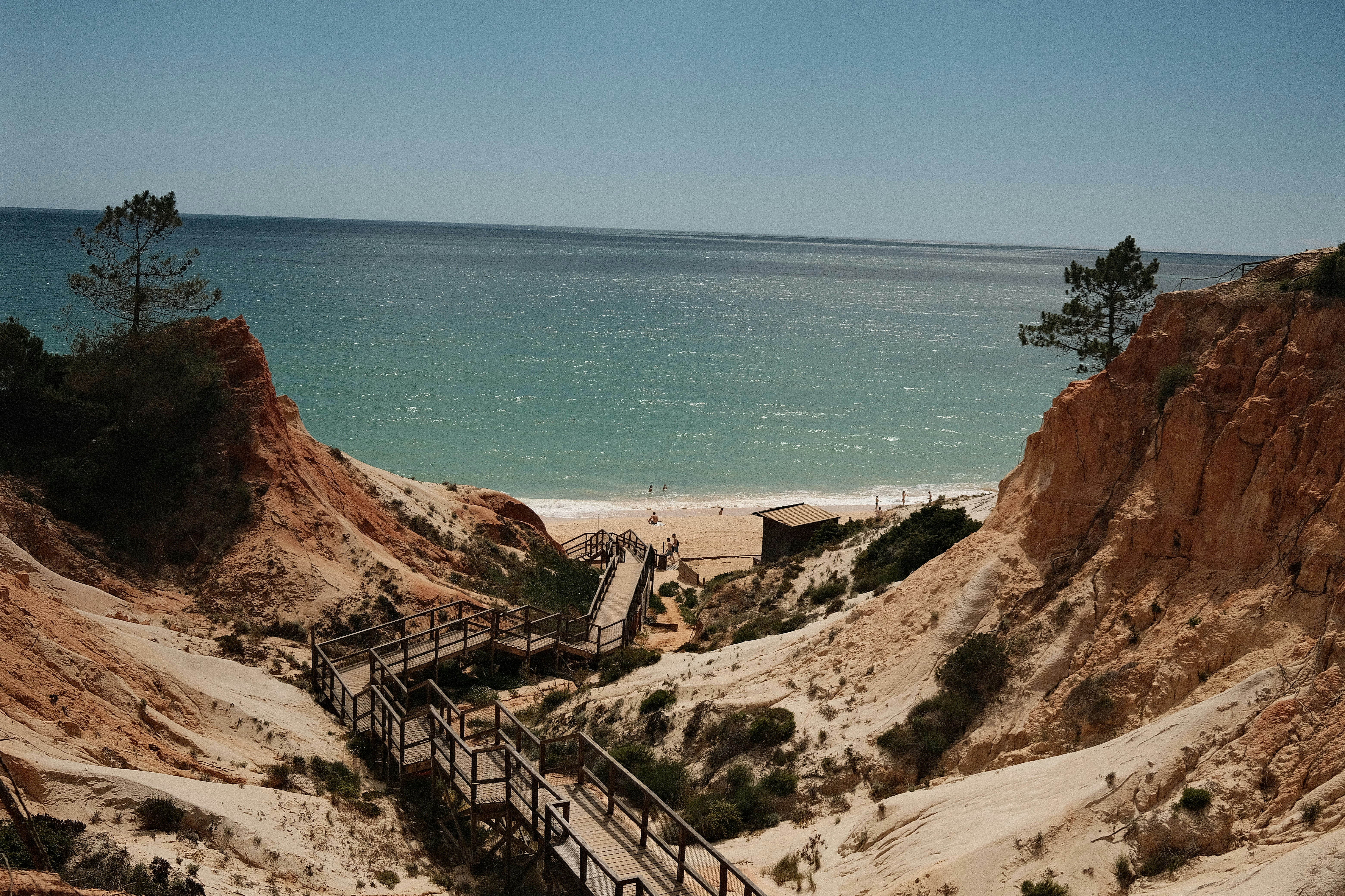 Pathway to the Sea: A Staircase Through Cliffside Sand and Sun