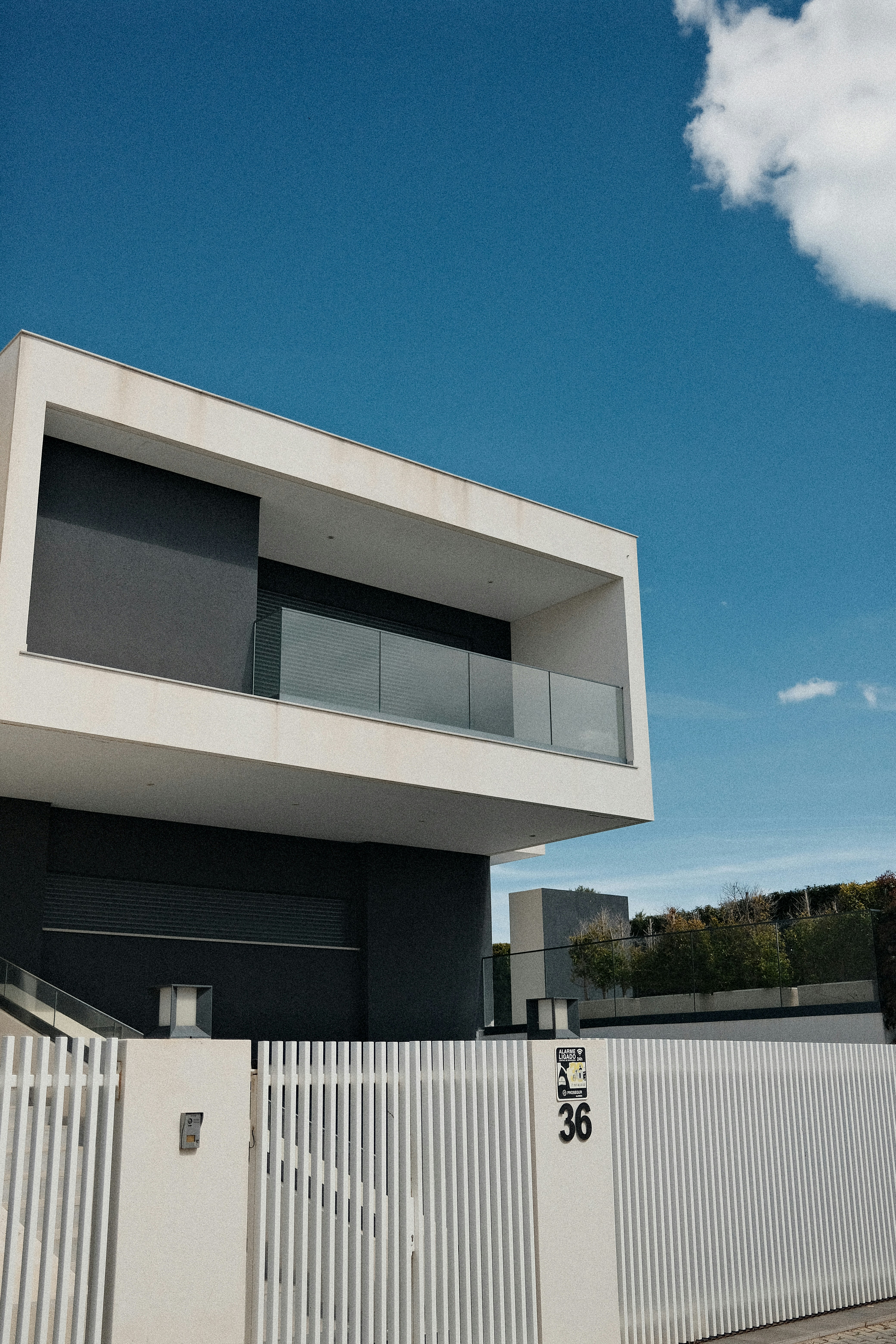 Modern White Box Overlook: A Geometric House Beneath a Clear Blue Sky