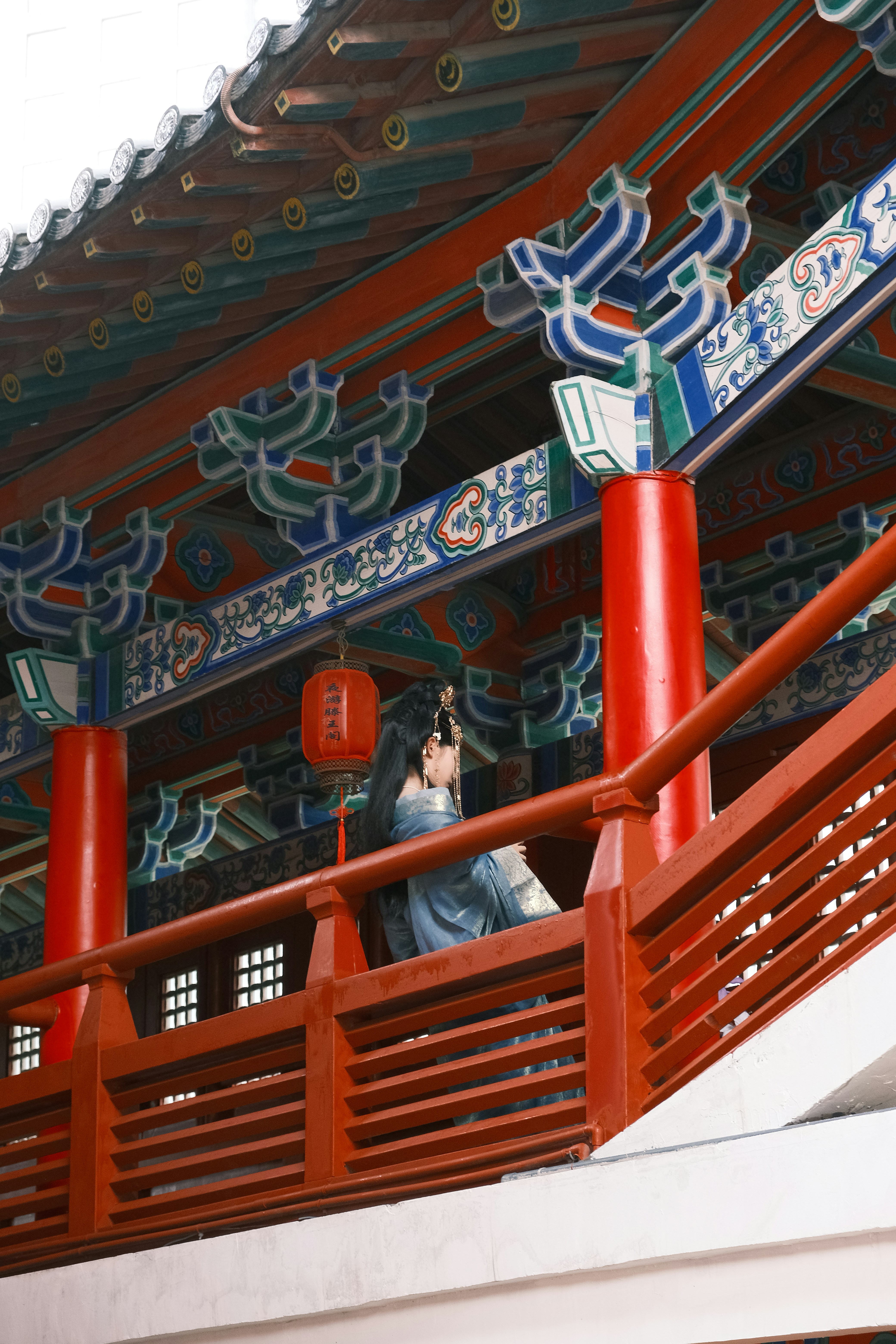 Red Columns and Painted Roof: A Quiet Moment on the Temple Balcony