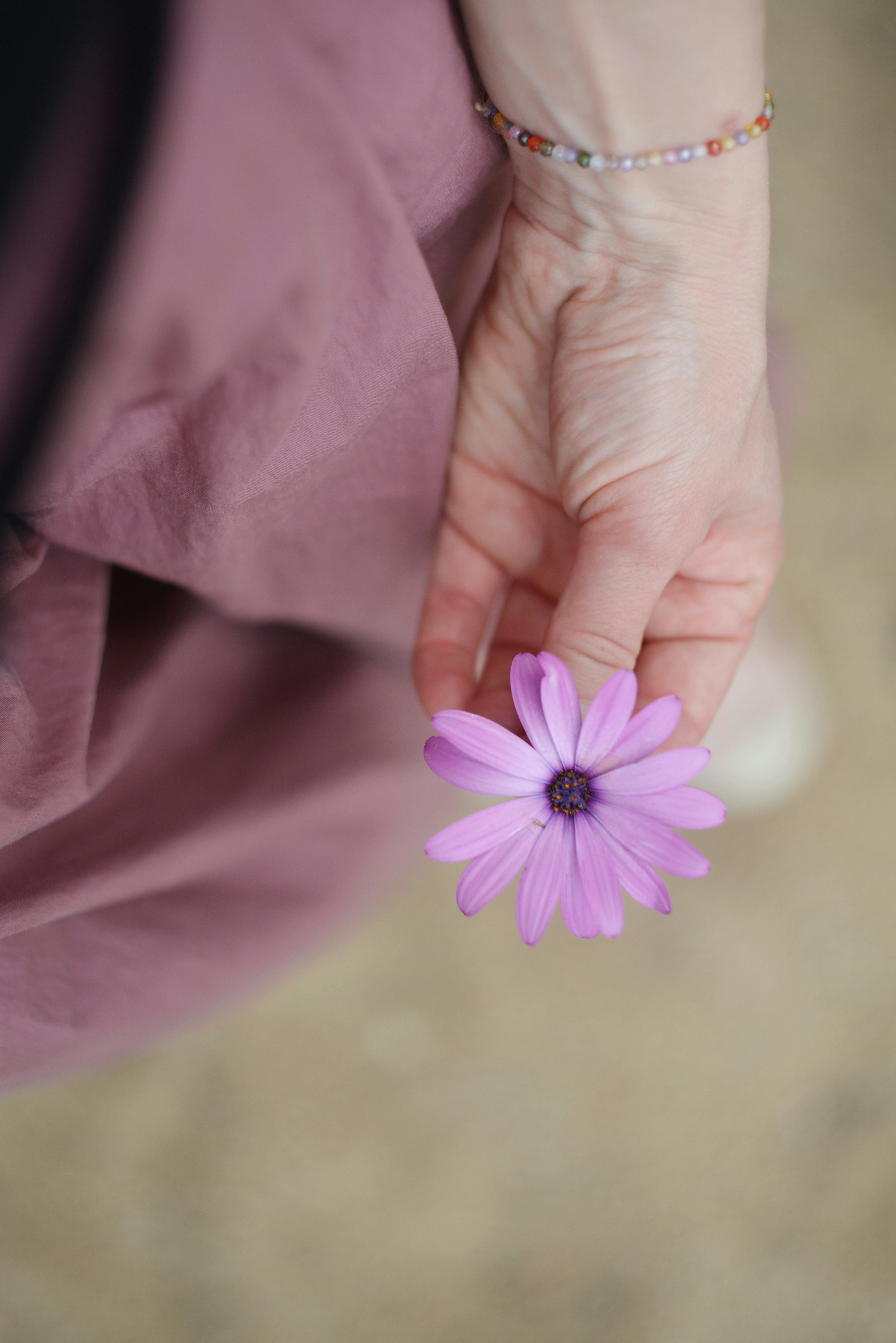 Purple blossom held along a graceful wrist