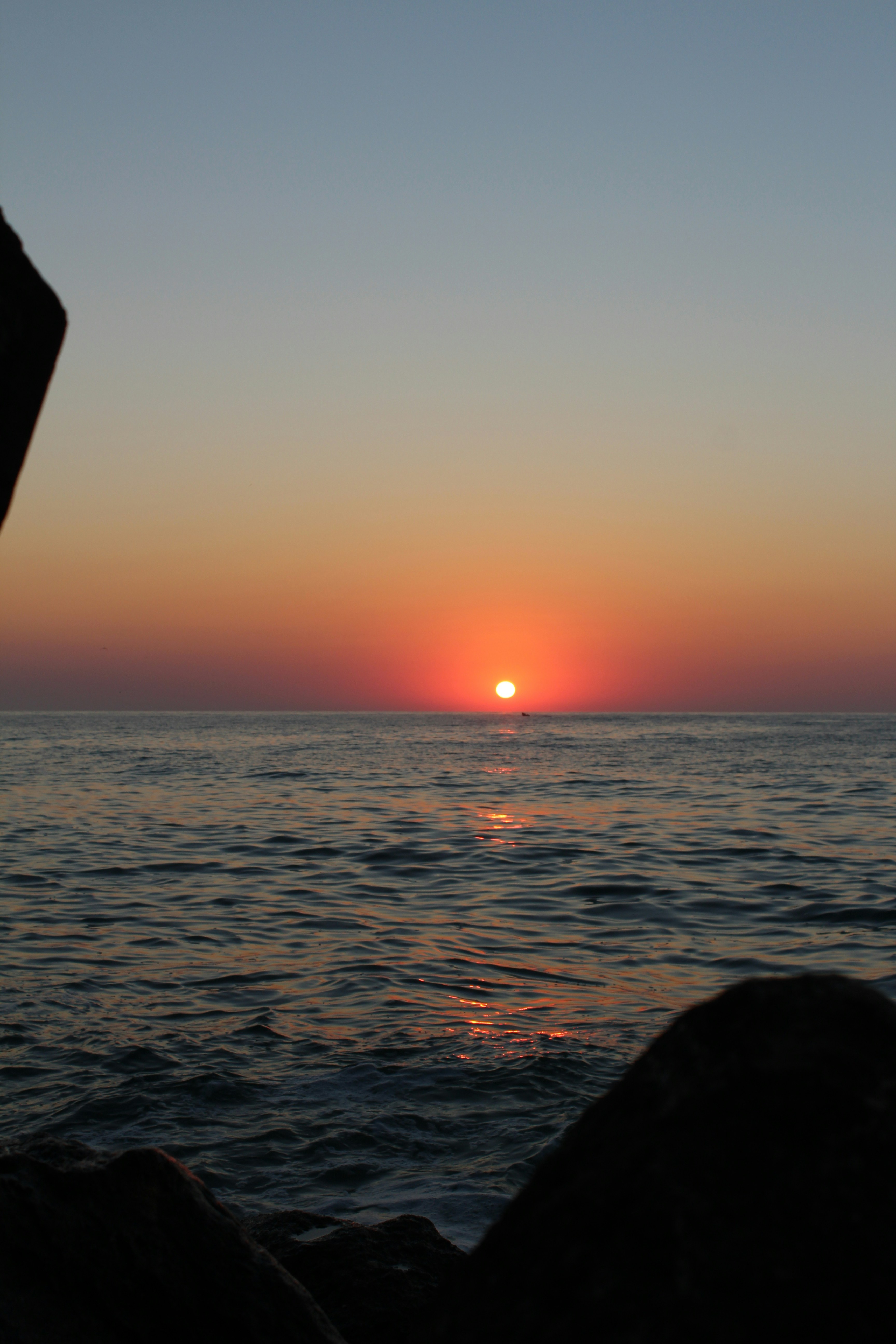 Orb of Dusk: Sun Dip Over a Quiet Sea