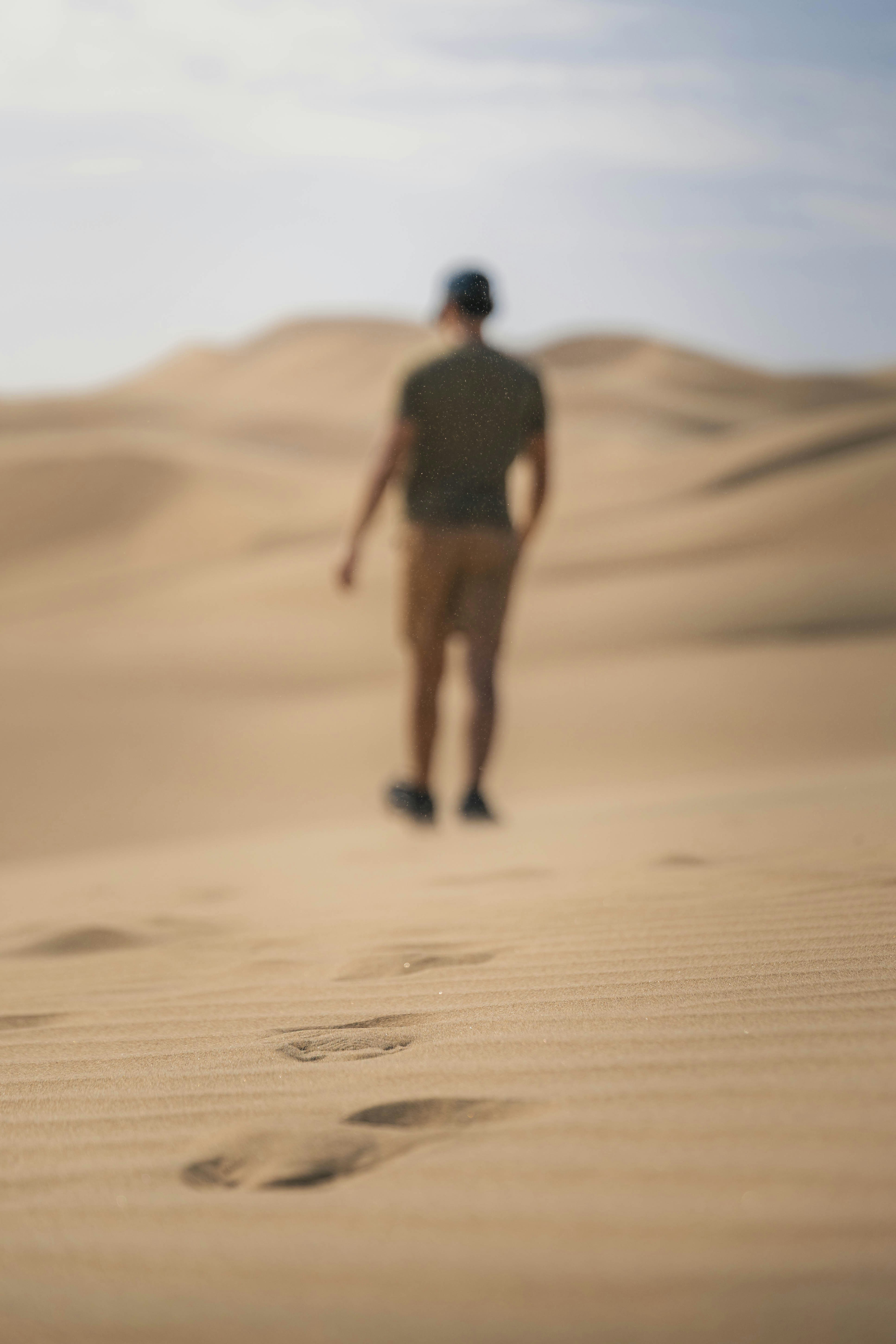 Footsteps in Silent Dunes: A Lone Wanderer Confronts the Horizon