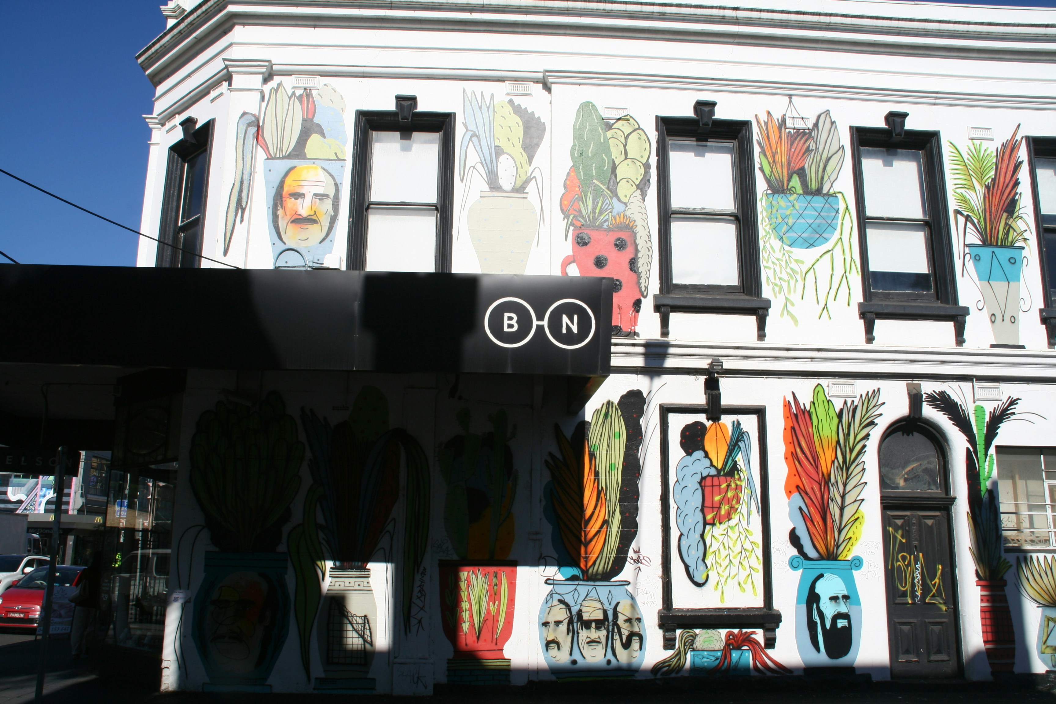 Bold mural storefront: BN signage under a color-splashed art façade