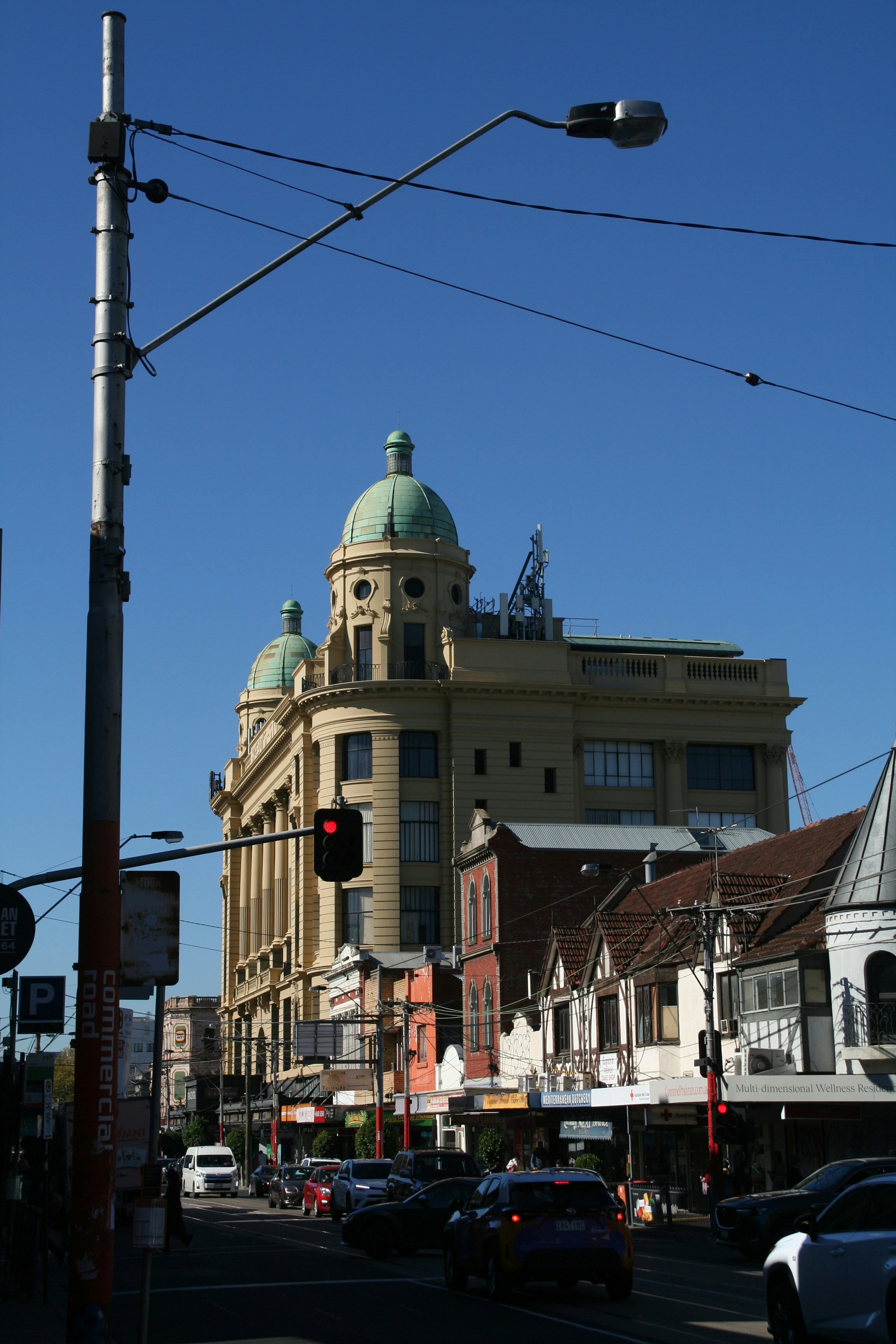Neo-classical Corner: A City Tower with Turquoise Domes Rising Above a Busy Arcade
