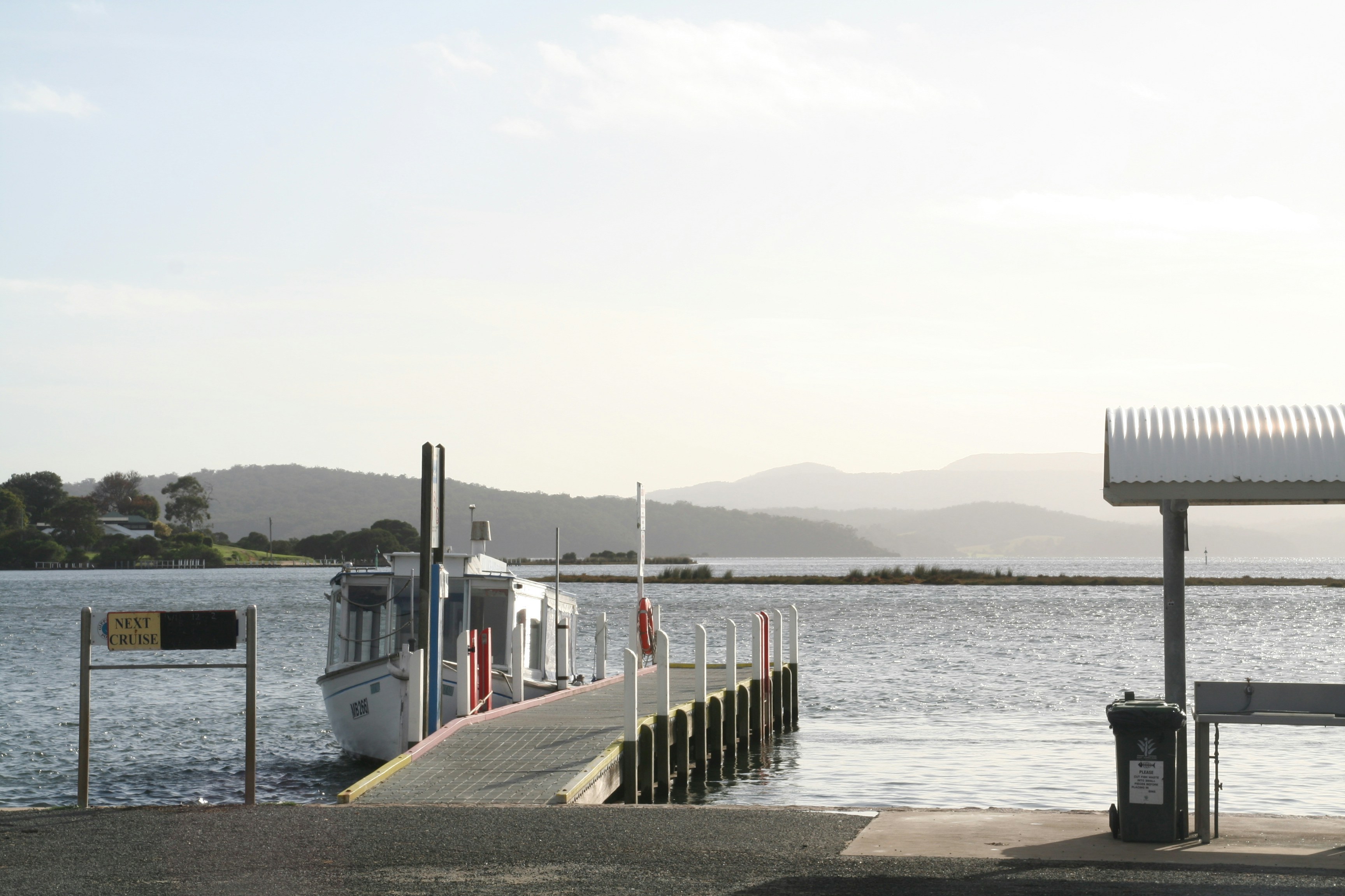 Dockside Quiet: Boats, Pier, and Distant Hills at Dusk