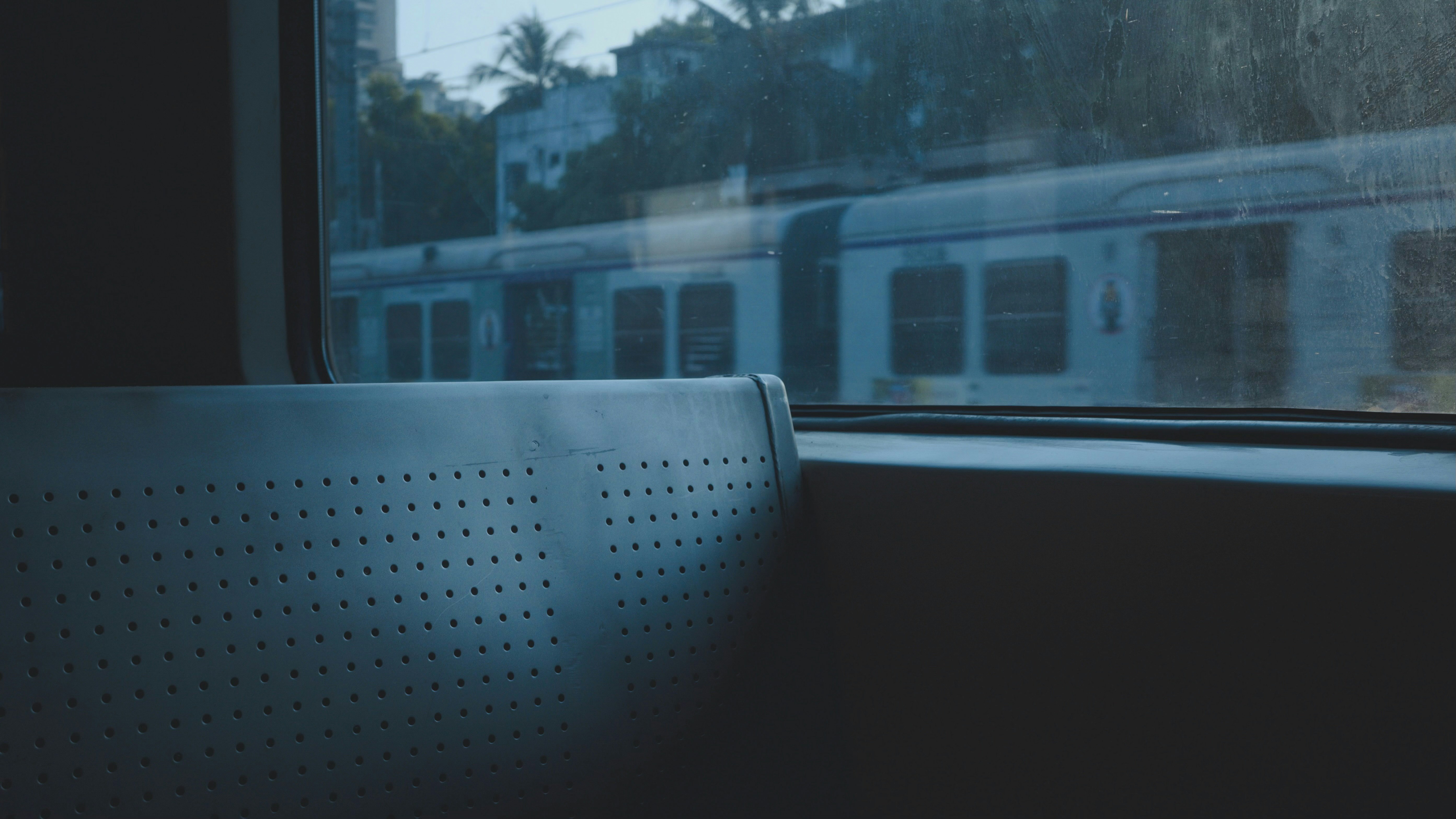 Blue Etched Silence: Train Car Window and Seat Silhouette