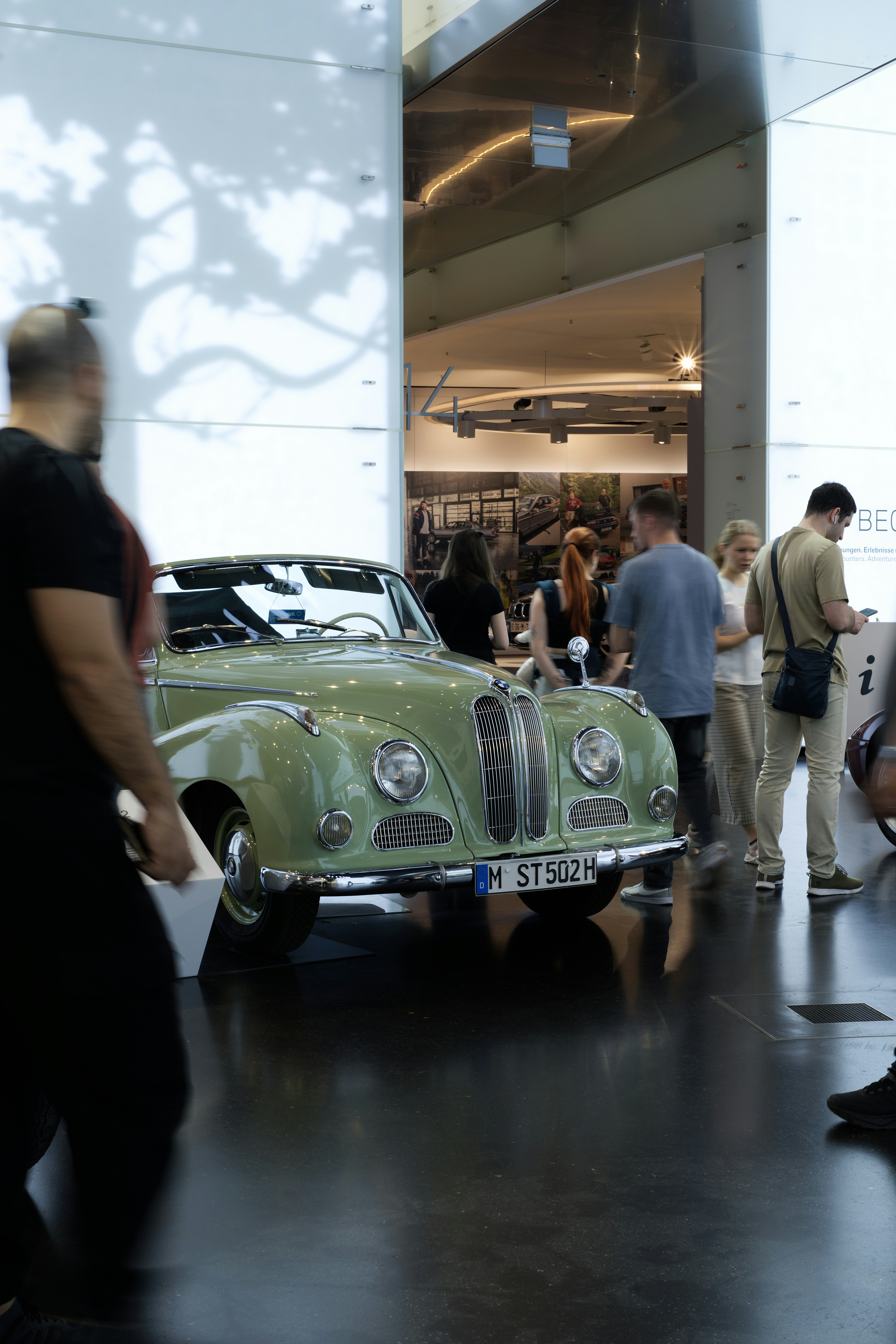 Green Classic on Display: A Vintage Aston in an Industrial Showroom