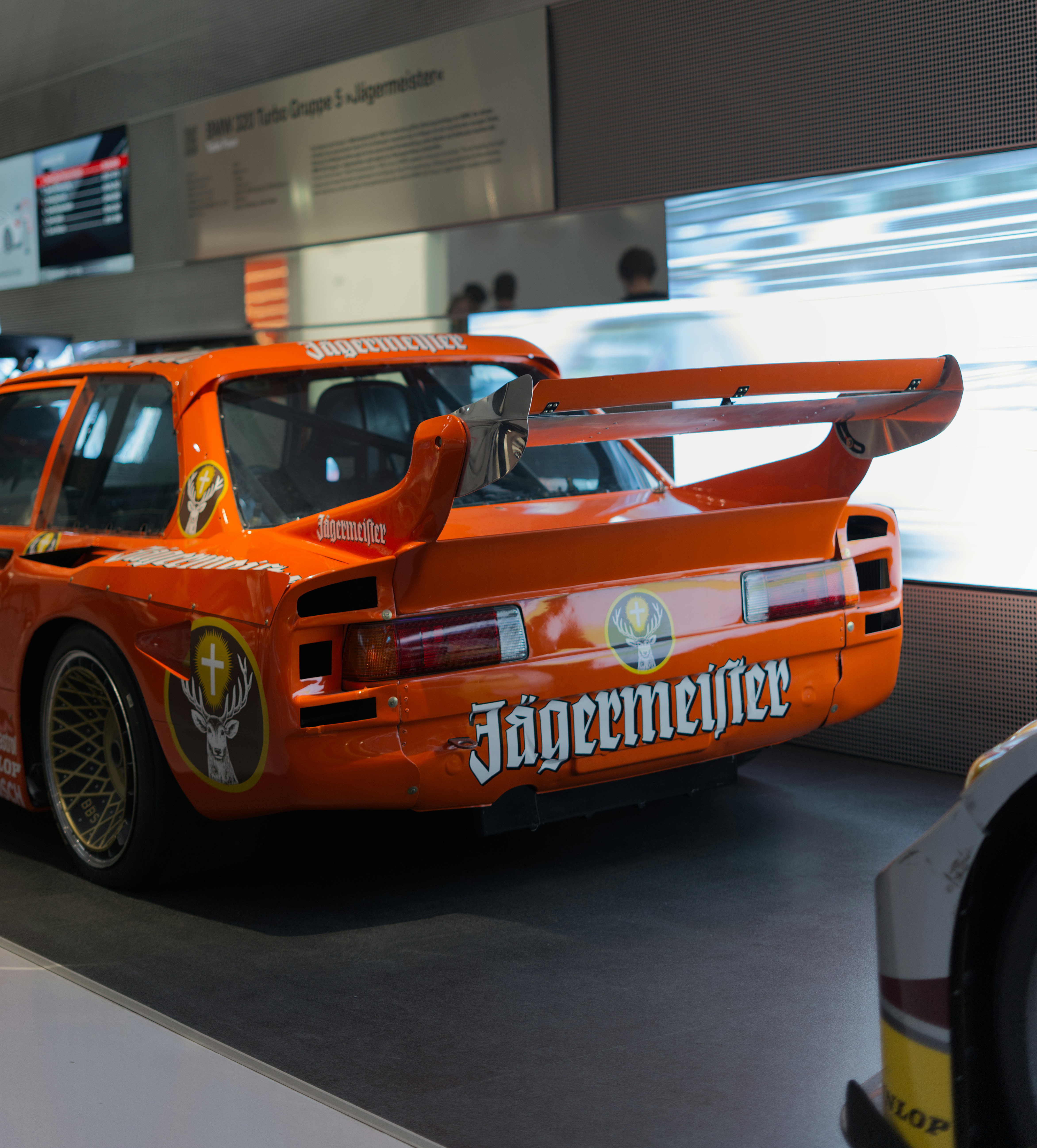 Jägermeister-liveried Group 5 Porsche: A Neon-orange Contender at the Exhibit