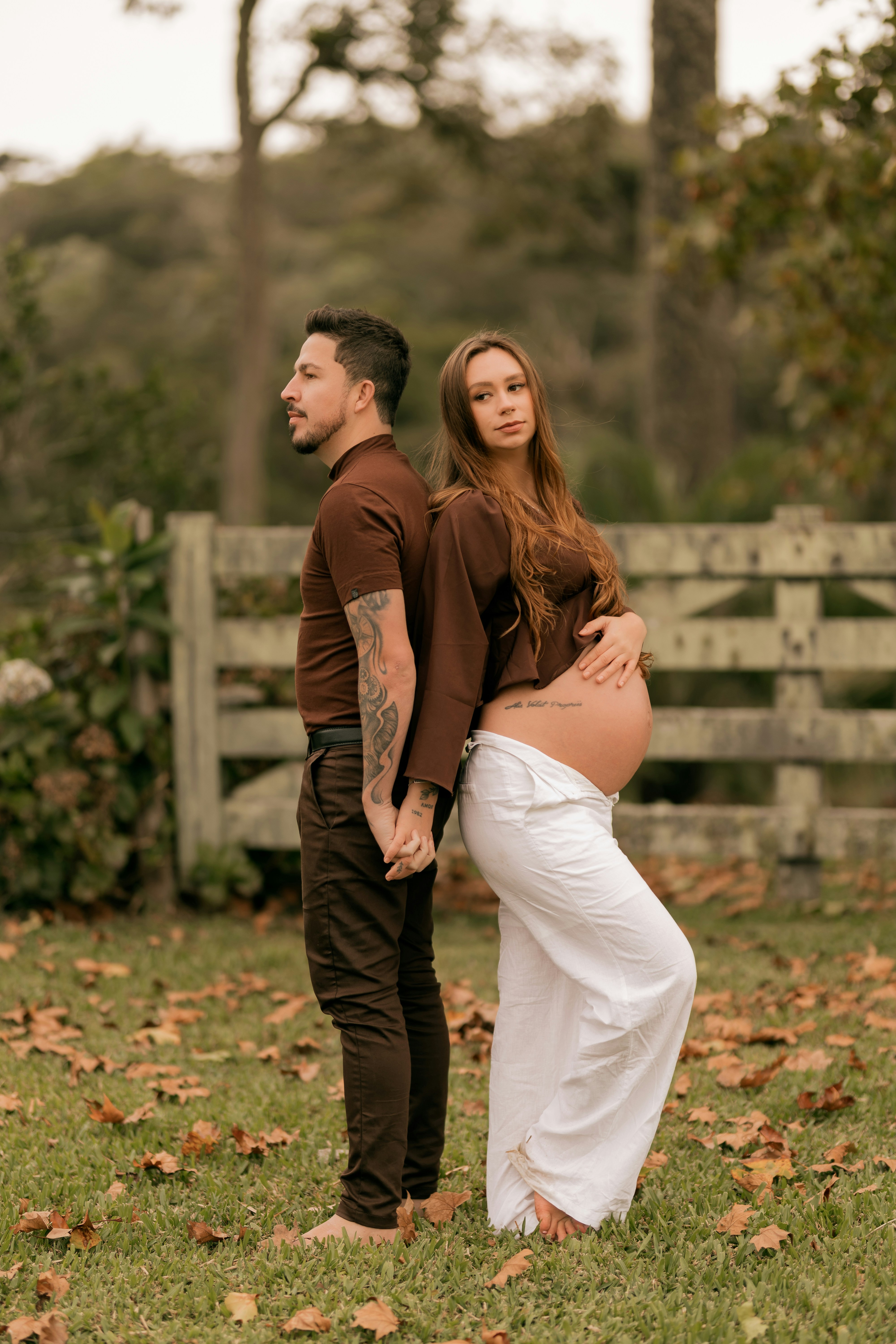 Pregnant woman and man holding hands outdoors