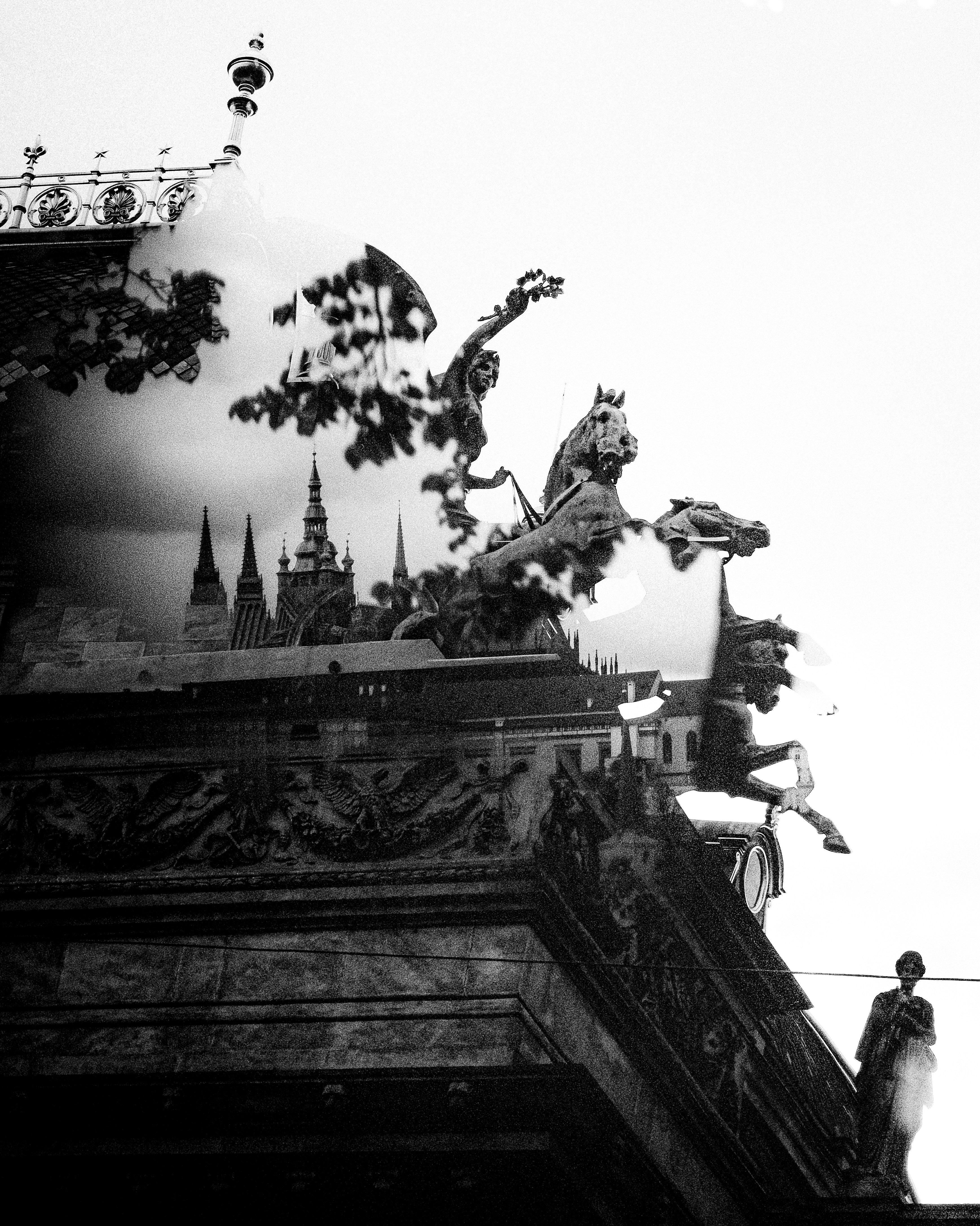 Rising Statues and Silhouettes Above a Historic Frieze