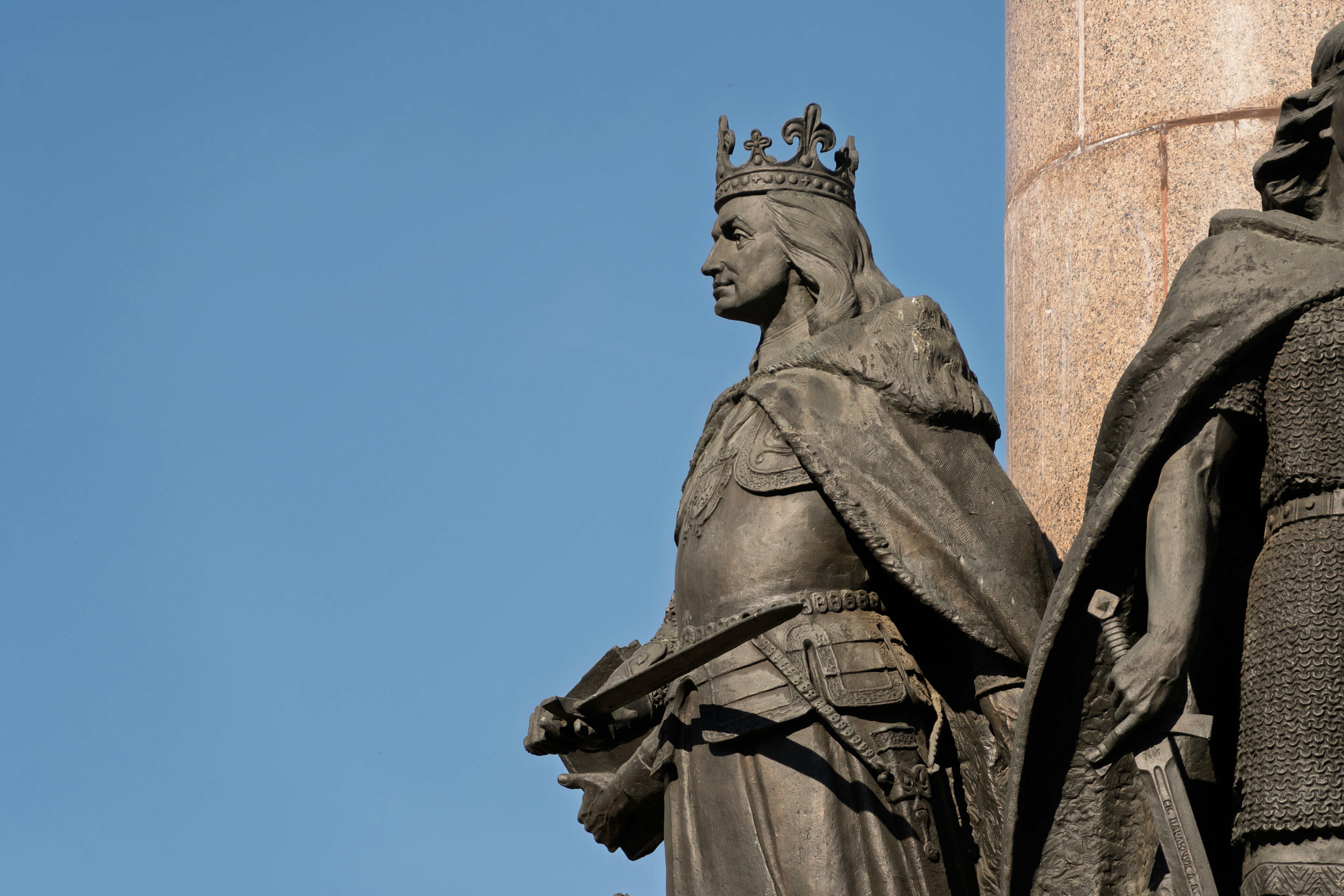 Crowned Protector: A Majestic Statue Against a Clear Sky