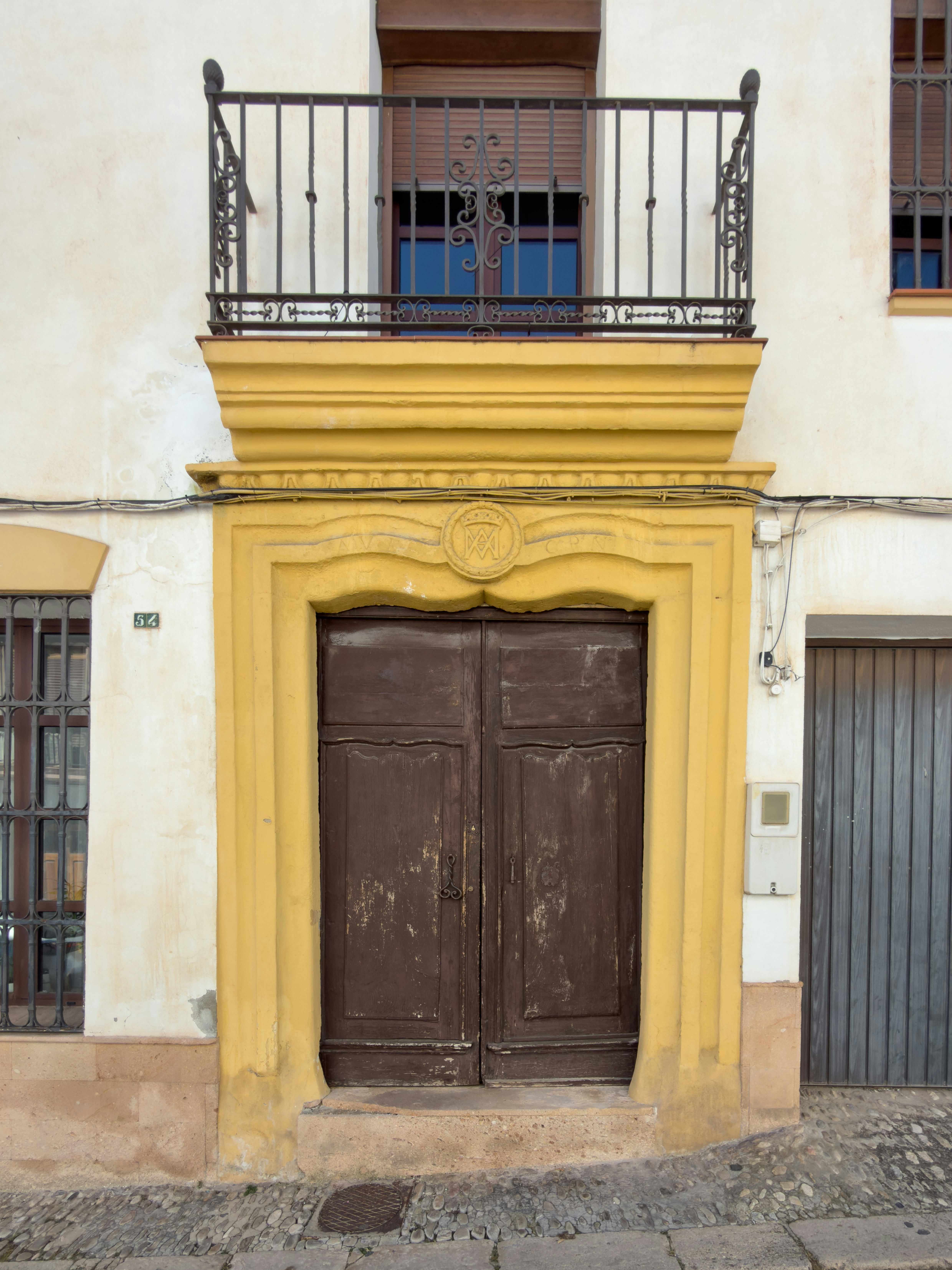 Yellow-arched Portal Under a Wrought-Iron Balcony