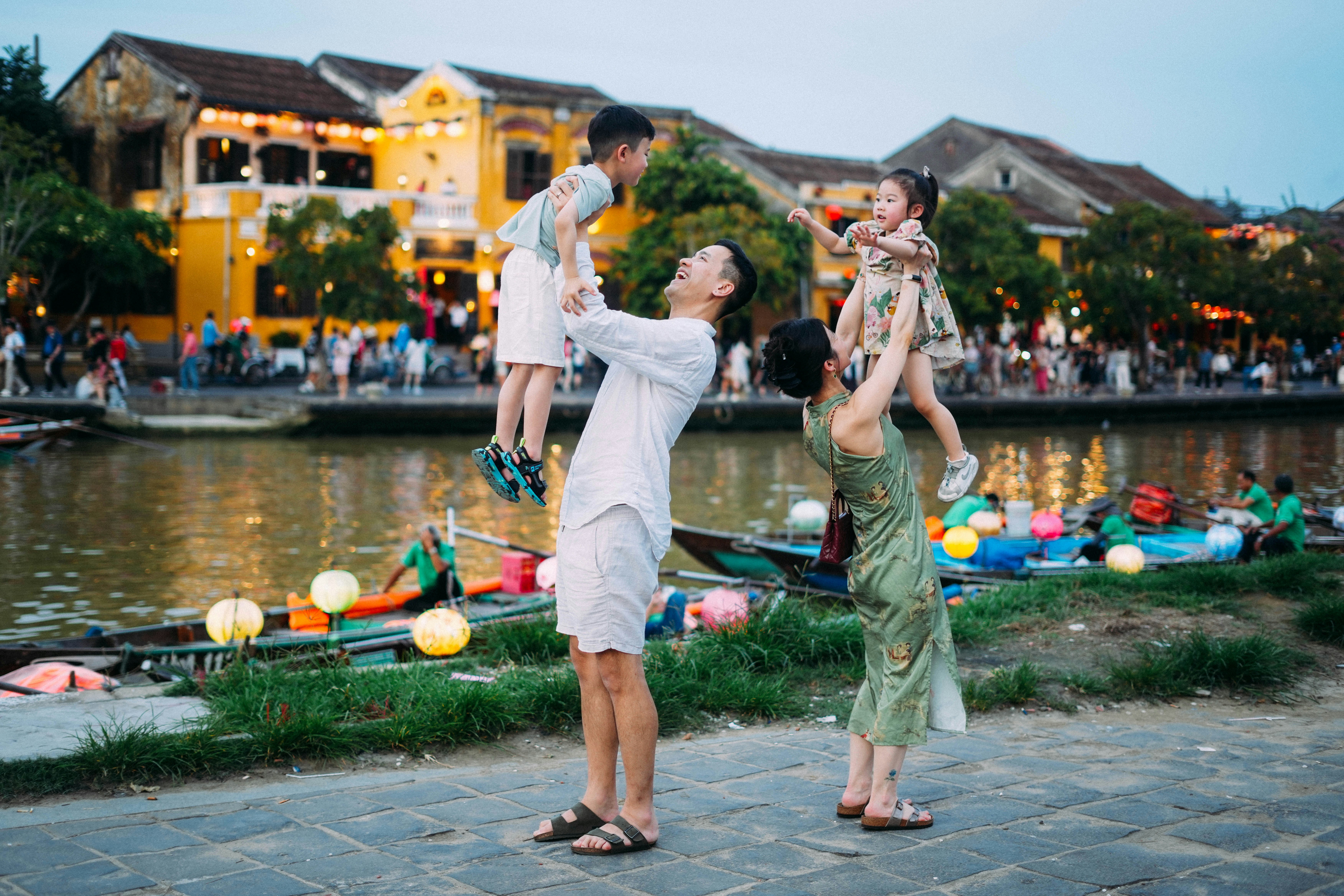 Joyful Family Dawn: A Father Lifts his Daughter by the Riverside