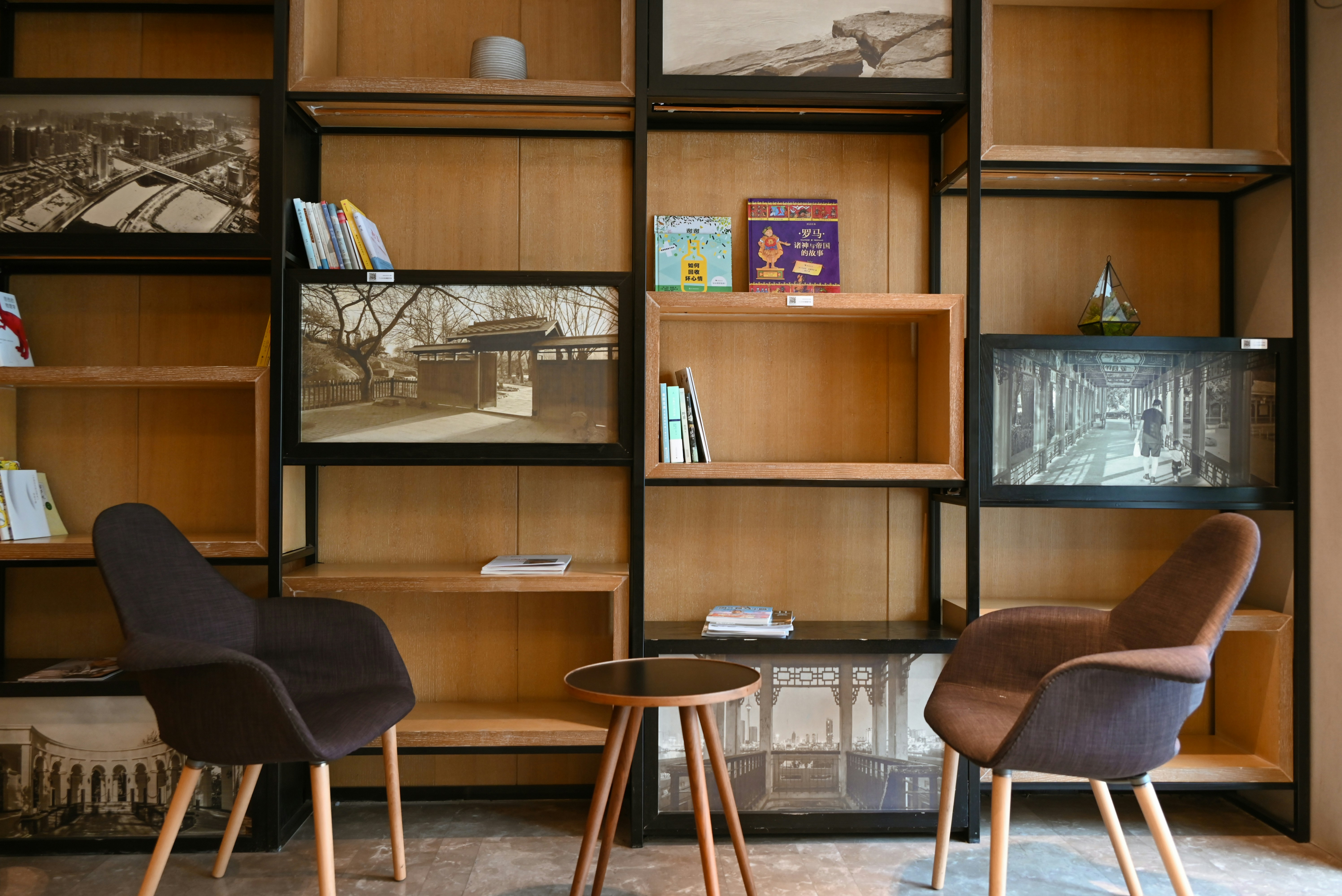 Mid-Century Seating Amid Framed Echoes in a Bookshelf Lounge