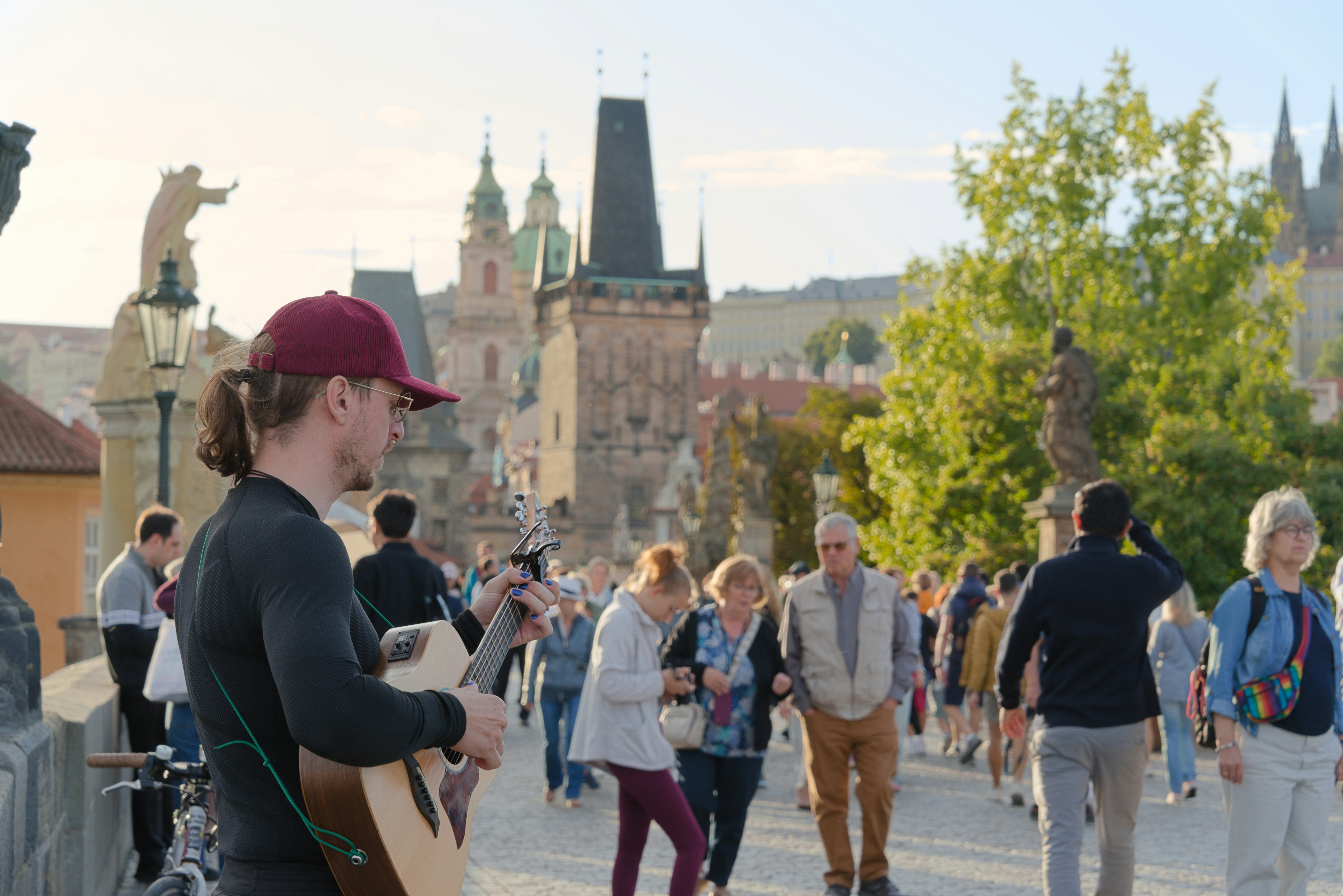 Guitarist in a cobblestone square draws a wandering crowd
