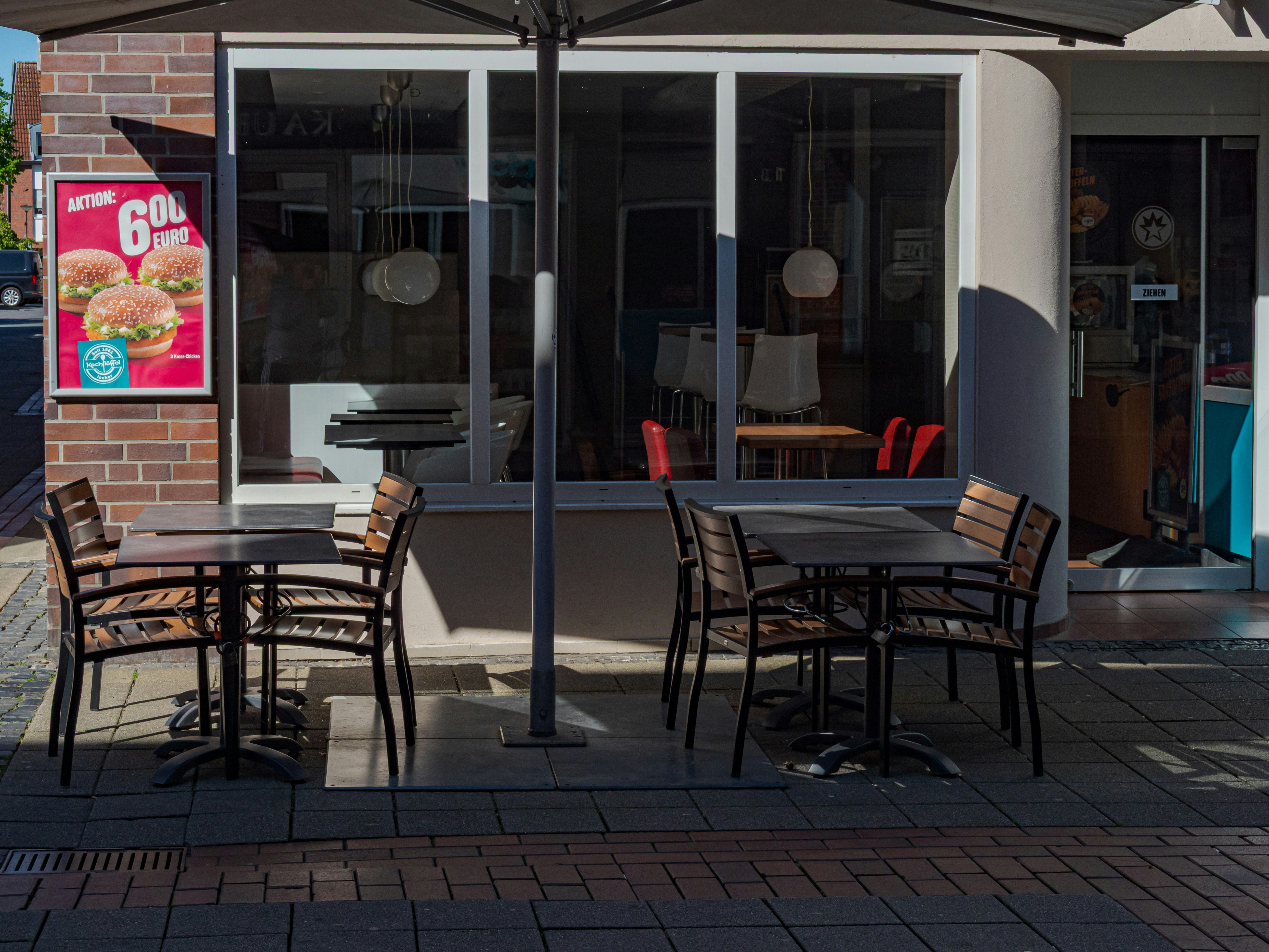 Quiet cafe terrace under a storefront awning