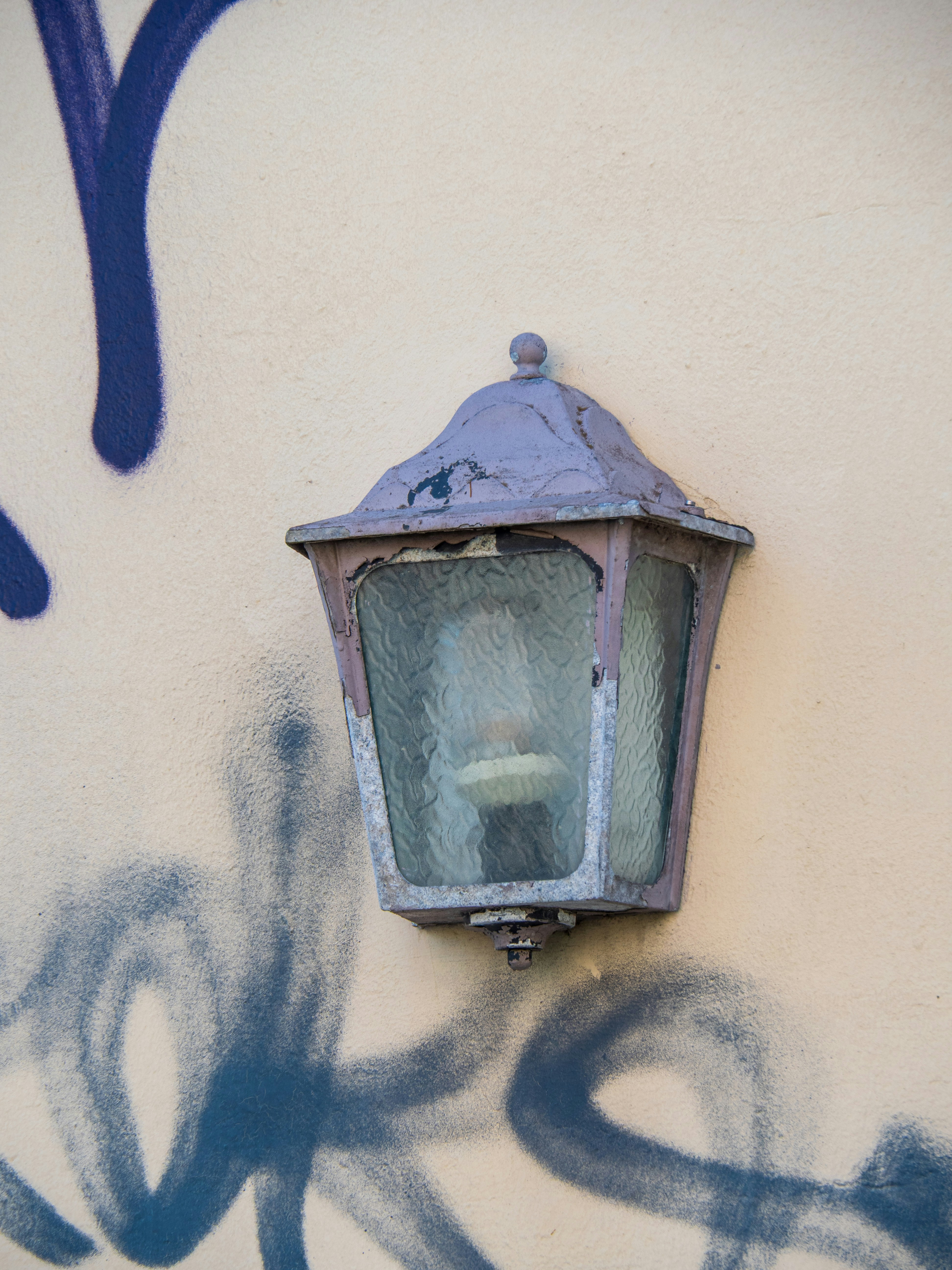 Dim antique lantern on a graffiti-brushed wall