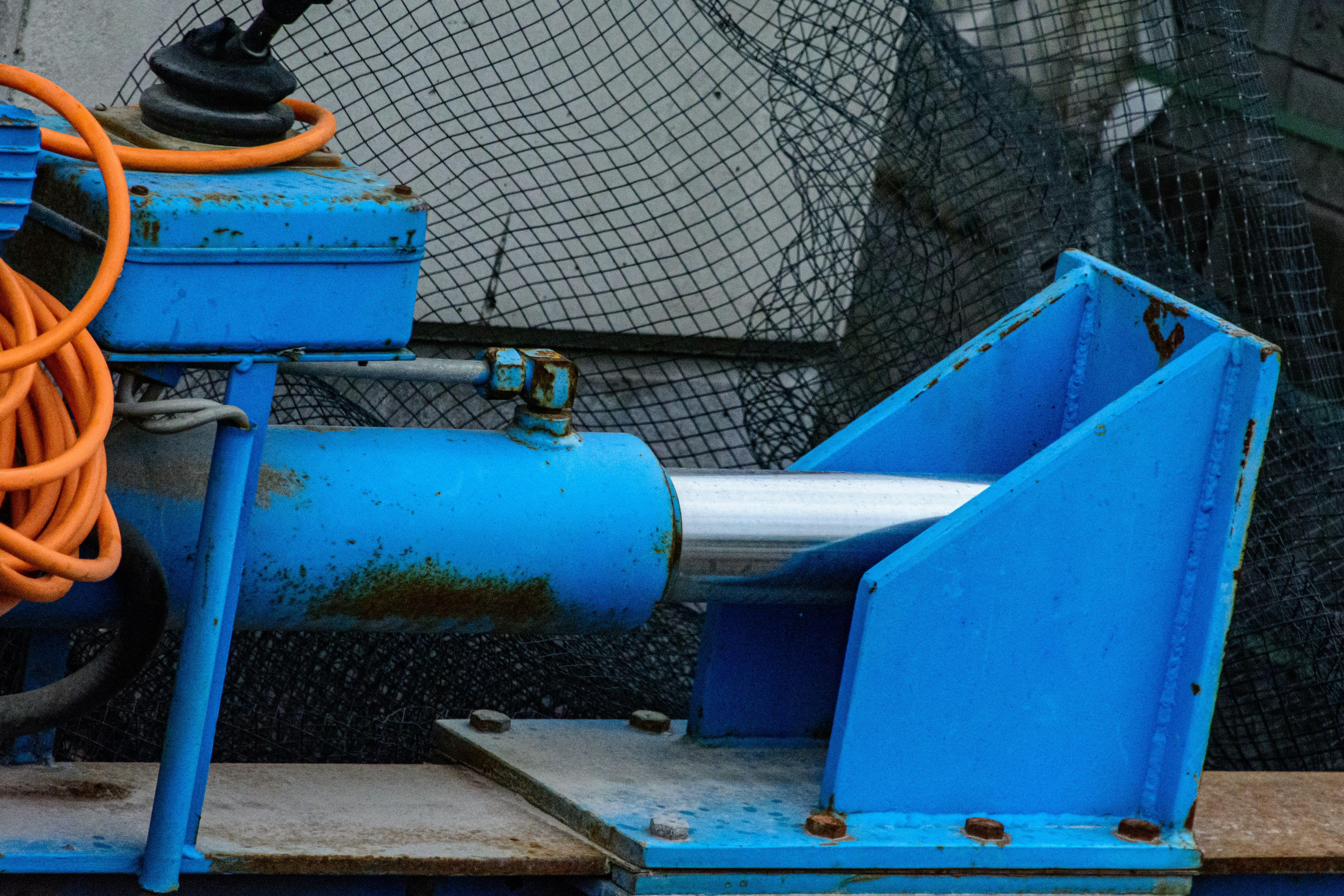 Blue Hydraulic Assembly Resting on a Weathered Platform