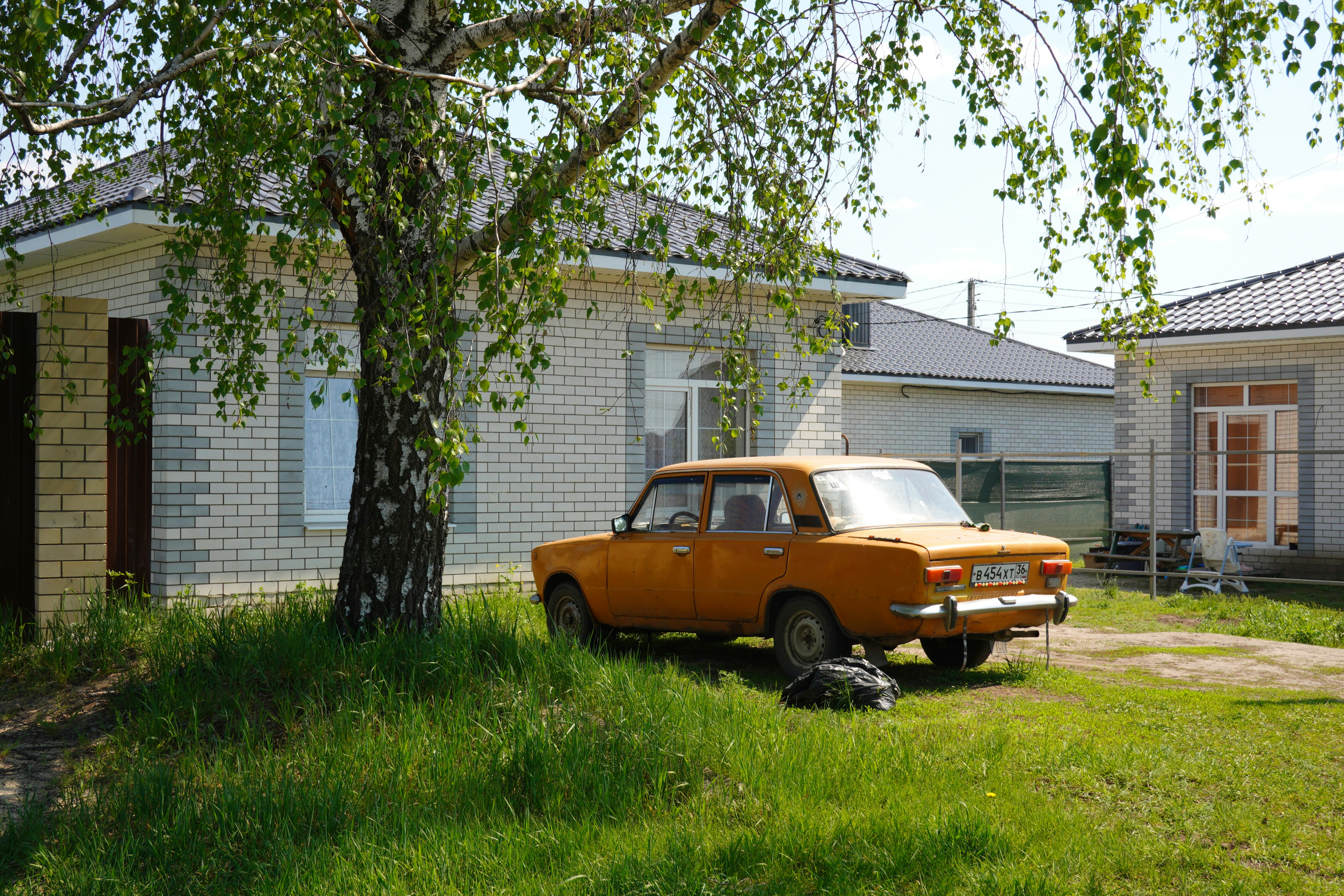 Orange Vintage Car Resting in a Quiet Yard