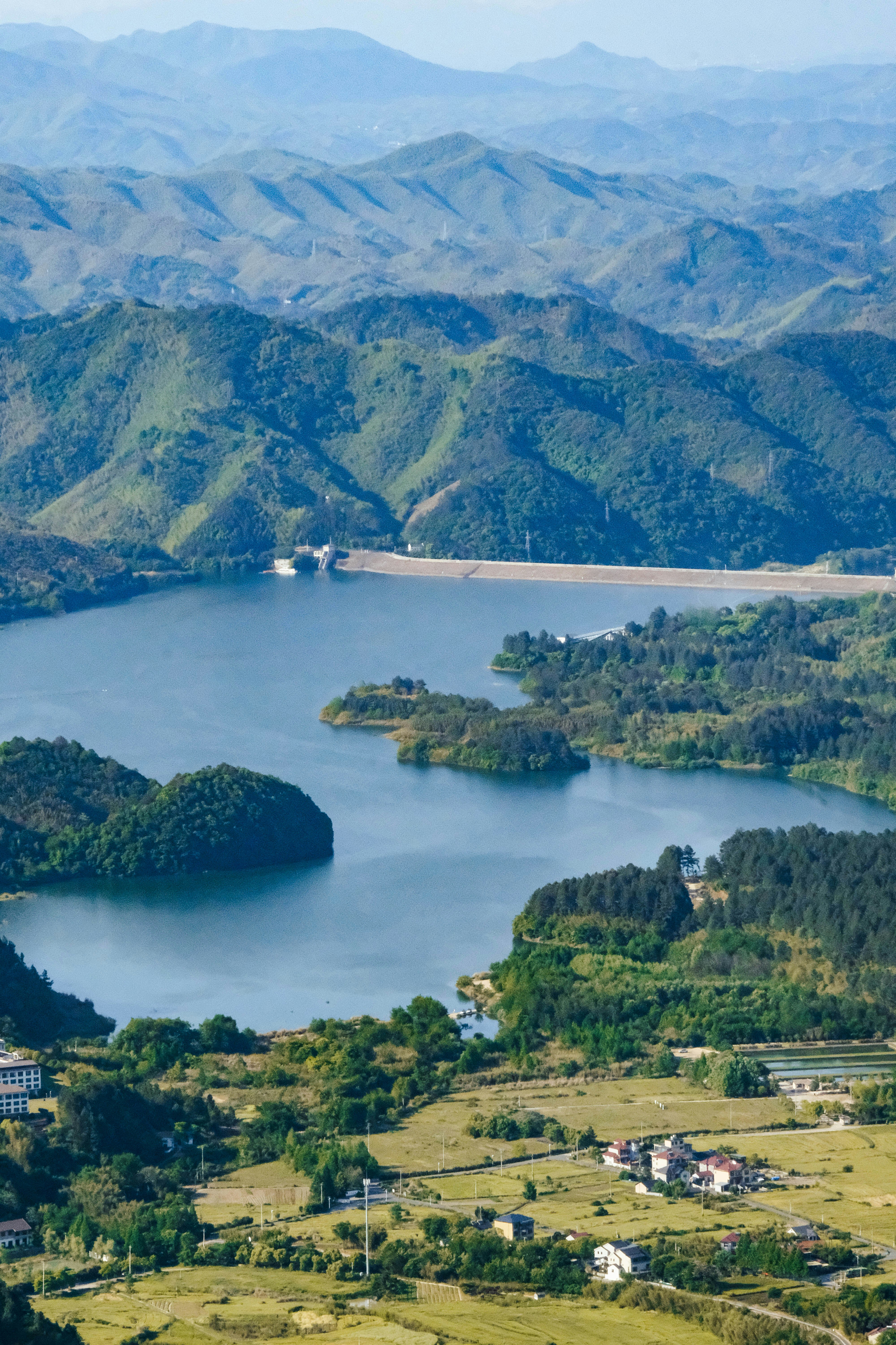 A Serene Reservoir Carved Through Green Ridges