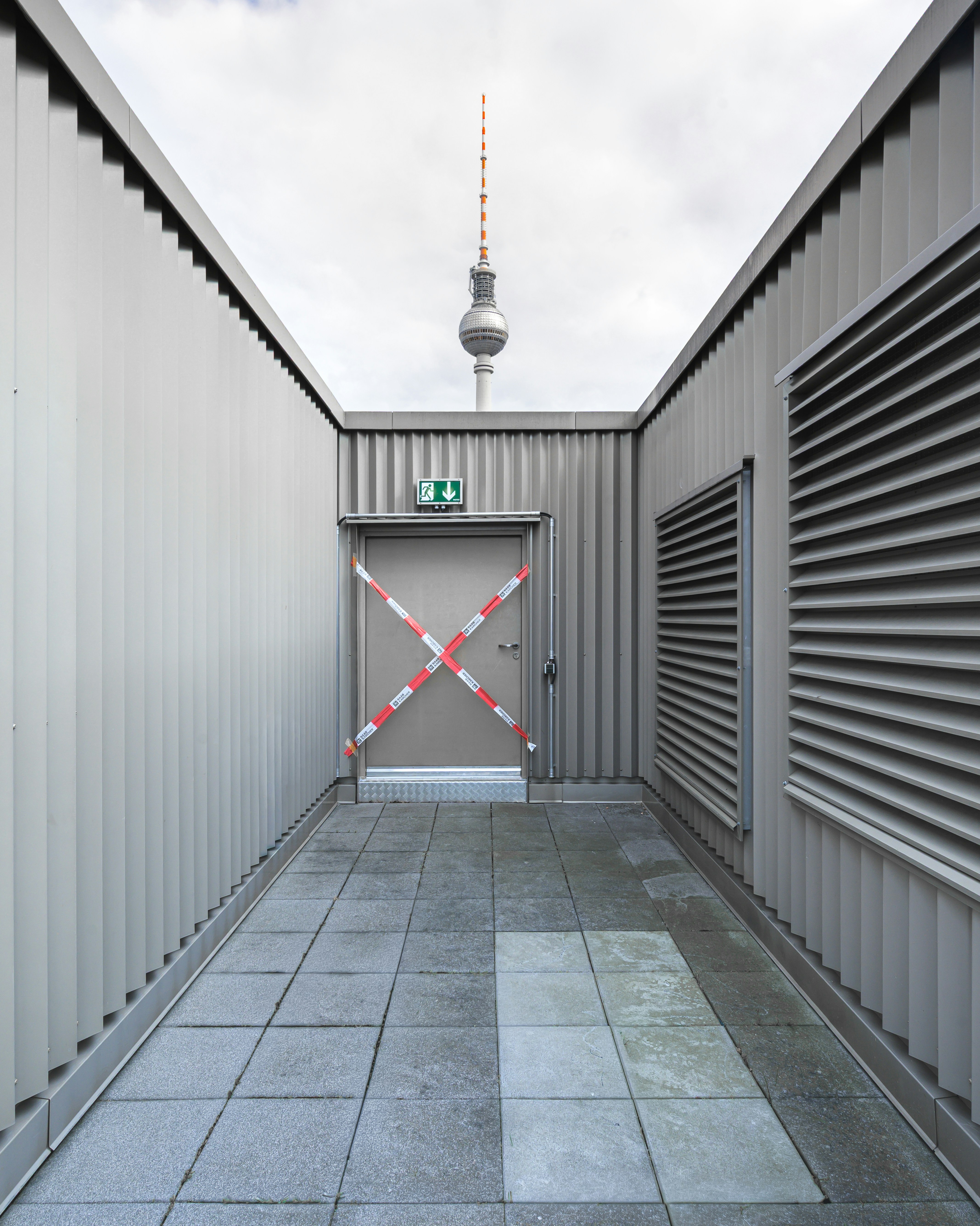 Constrained Corridor: A Rooftop Exit Framed by Industrial Walls
