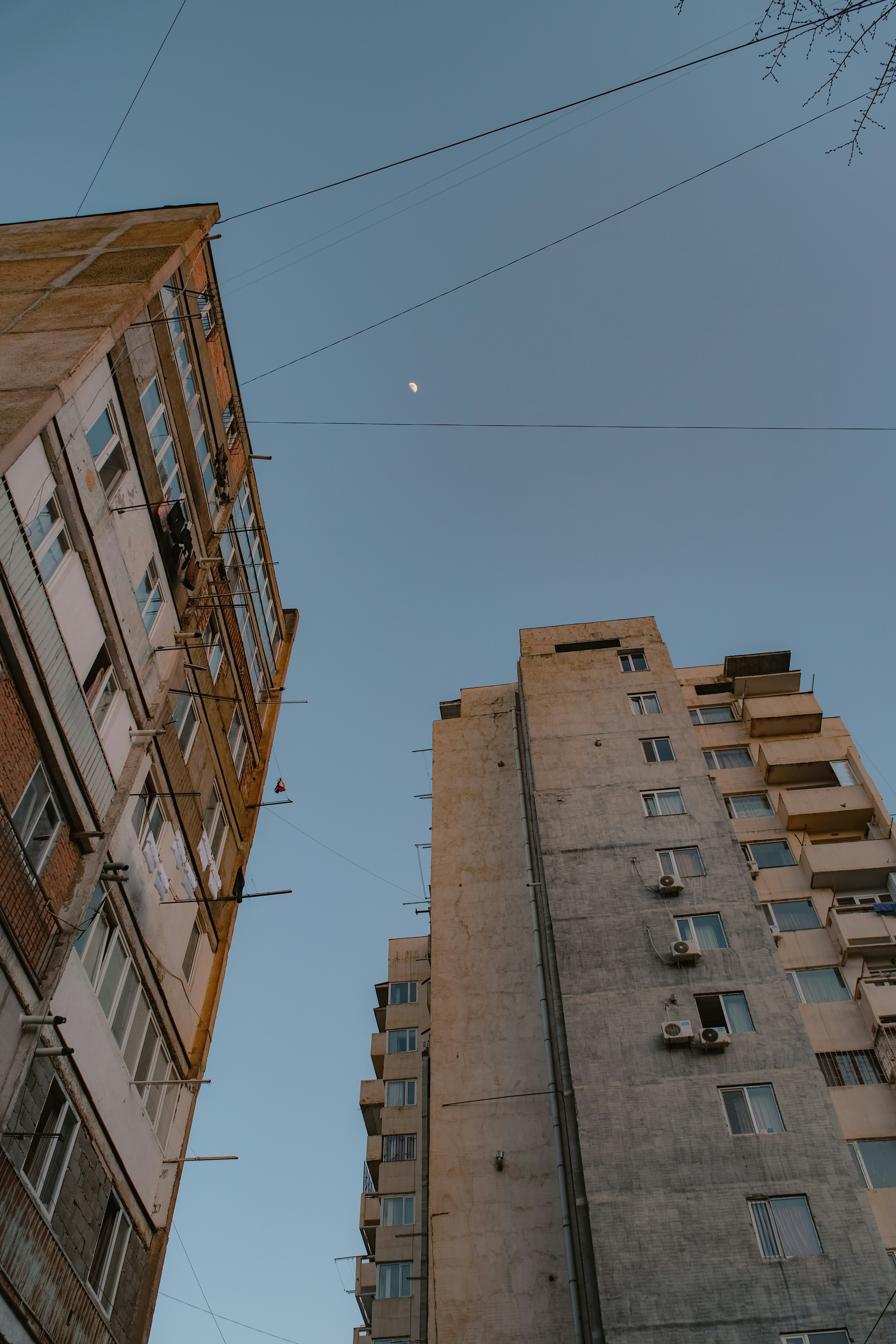 Urban Skyward: An Alley Between Buildings Under a Clear Azure