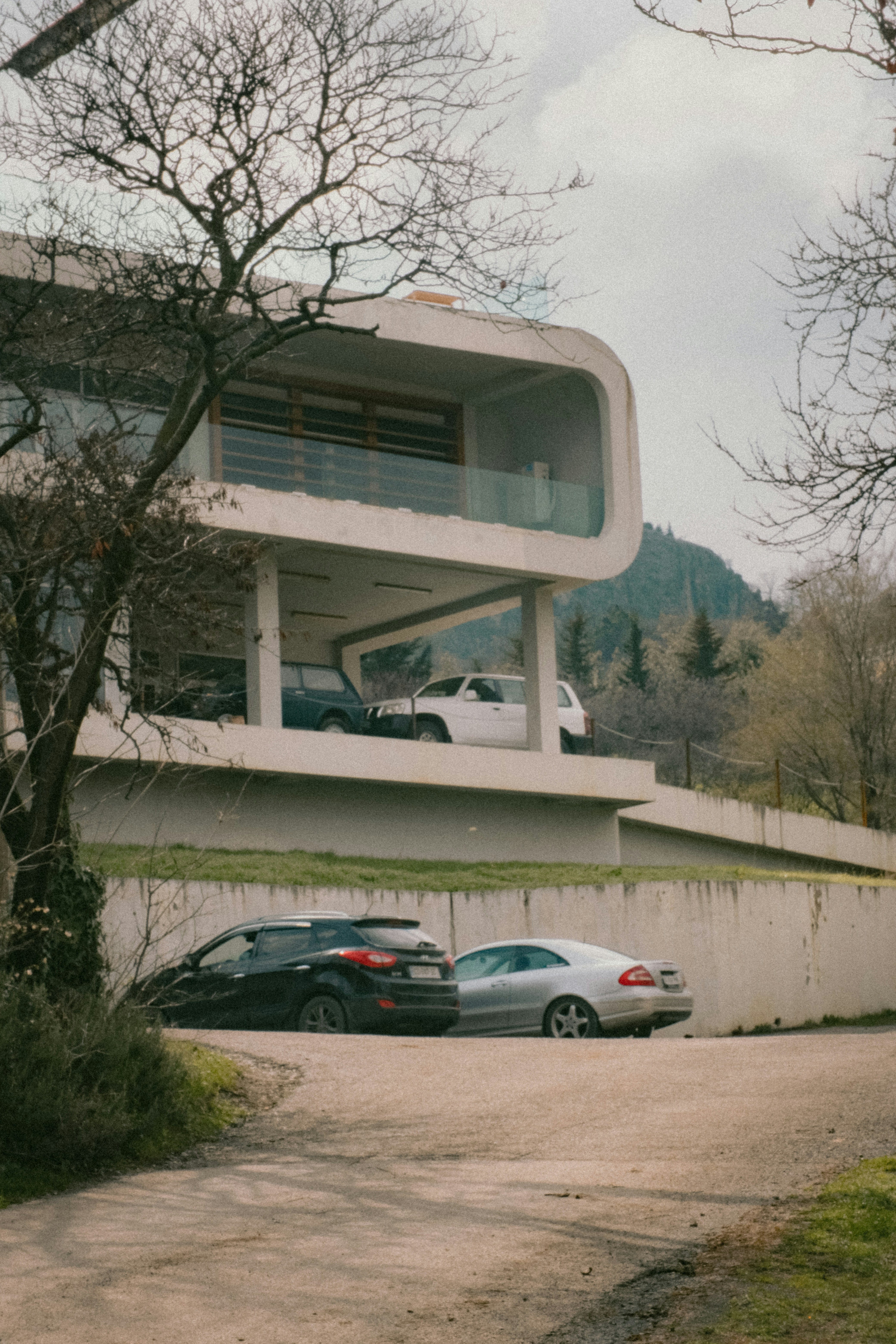 Mid-Century Modern Drive: Cars under a Curved Terrace