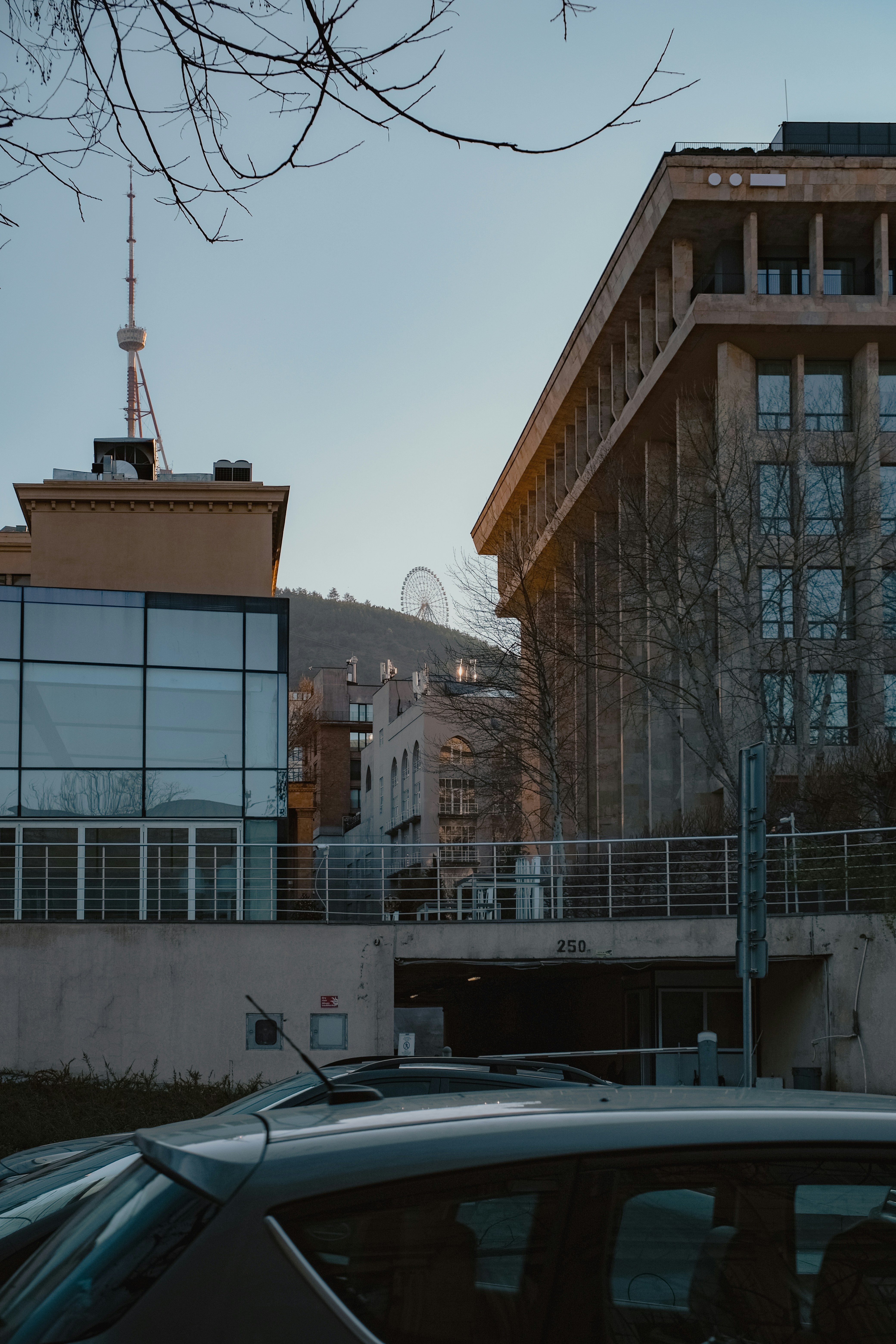Cityscape Quiet: A Ferris Wheel Halo Behind Modern Architecture