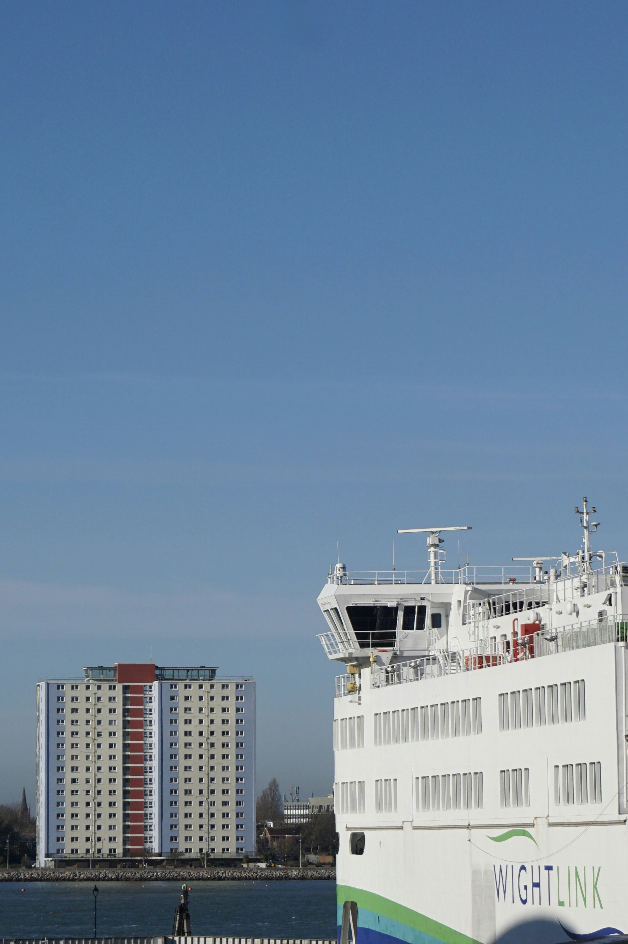 Harbor Contender: A White Ferry Anchored at Dusk Toward Quiet Cityscape