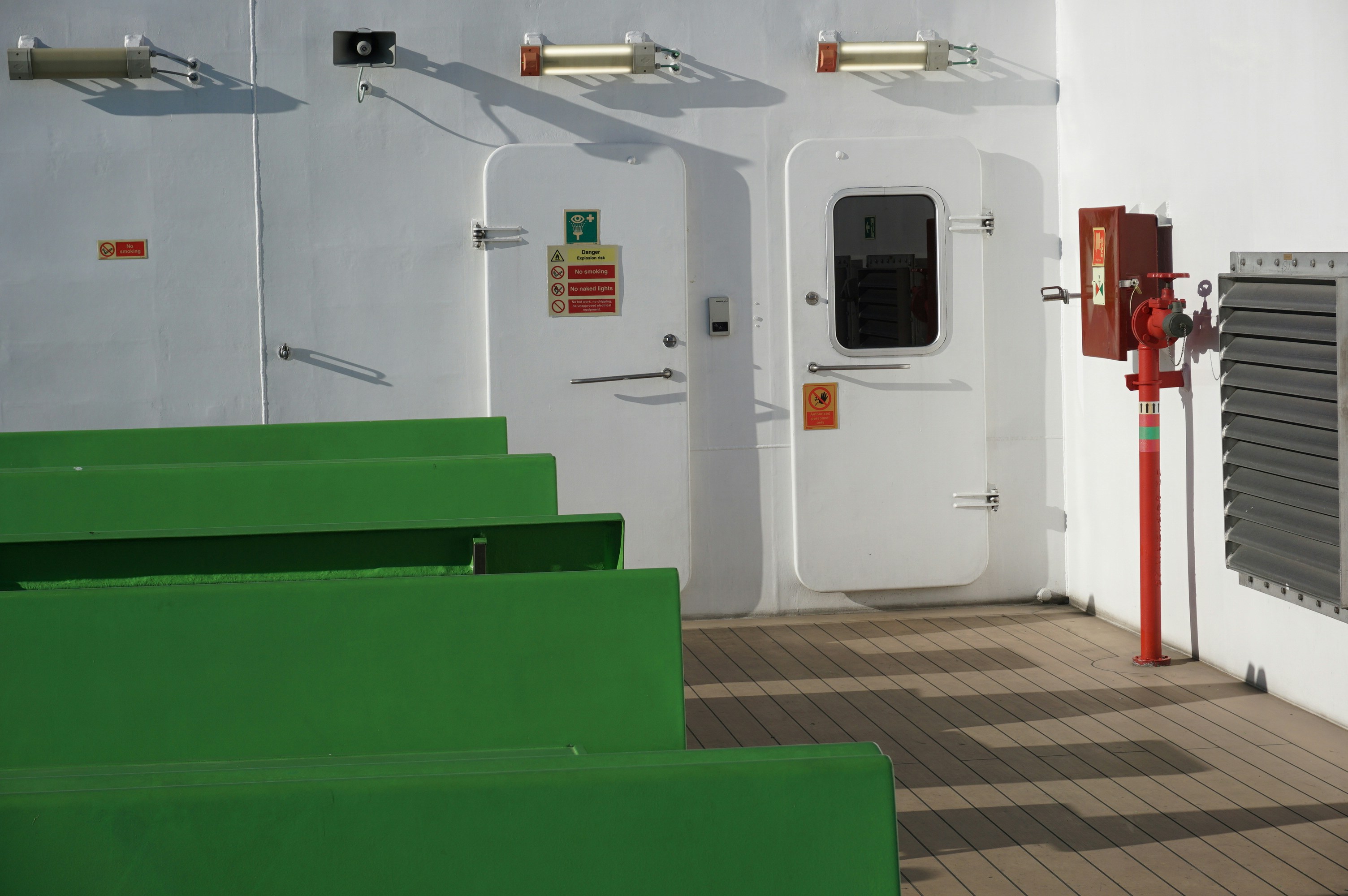 Industrial Deck Lines and Green Seating on a Ship