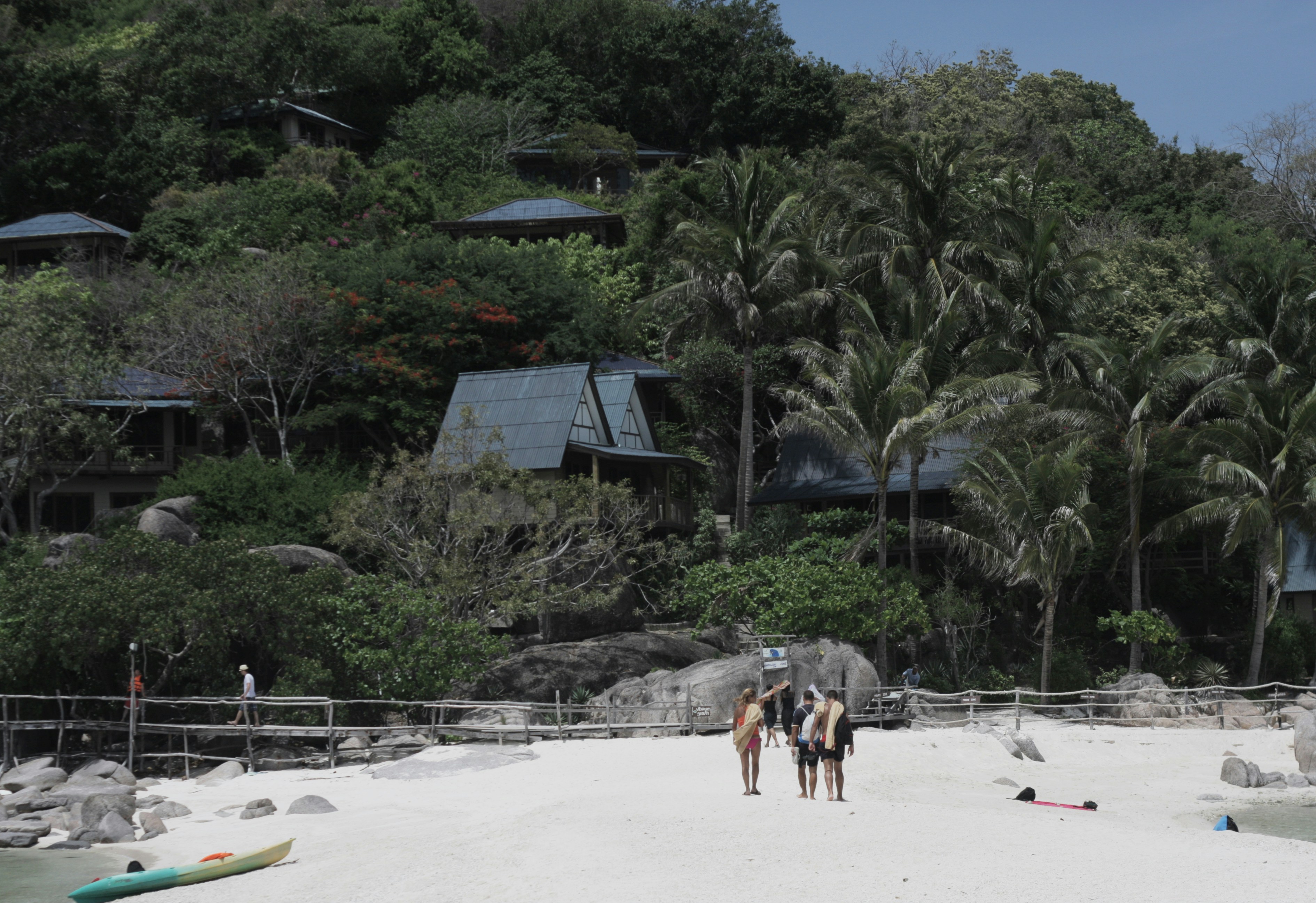 Sunlit Beach Party: A Small Group Draws Focus on White Sands