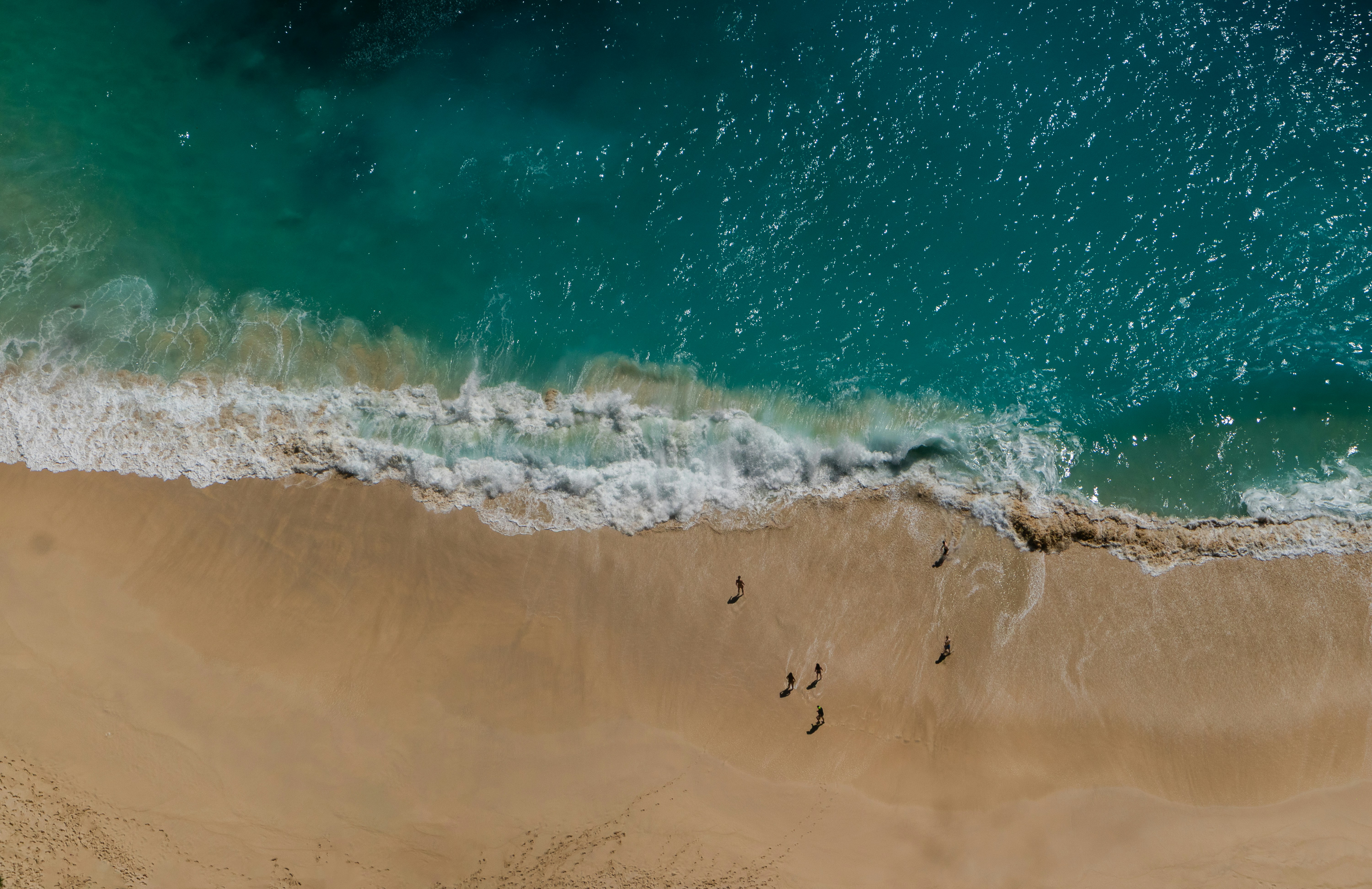 Aerial Coastline: People as tiny specks along the shoreline