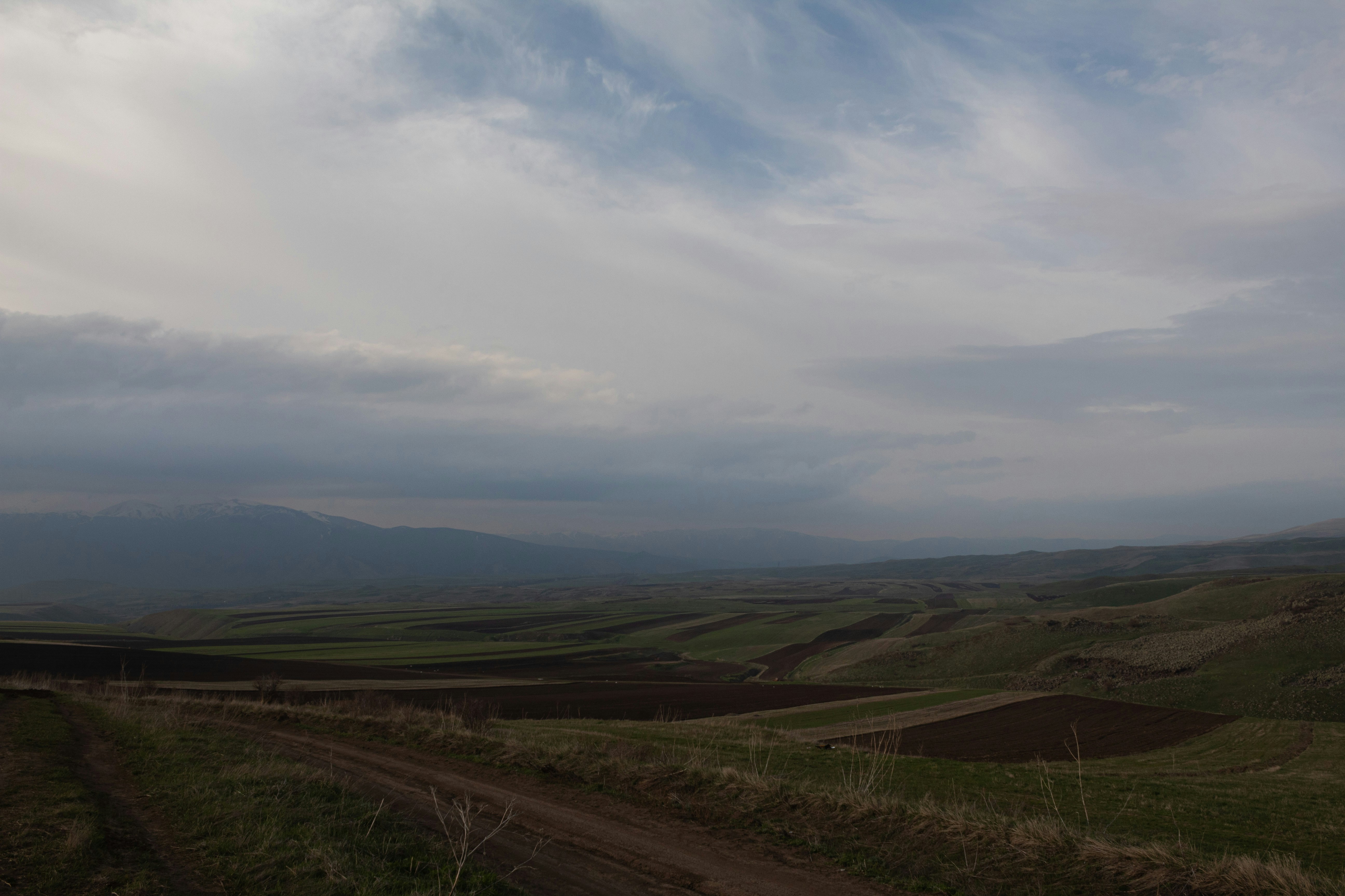 Hushed Valleys: a Rugged Tapestry of Farmland Under Soft Sky