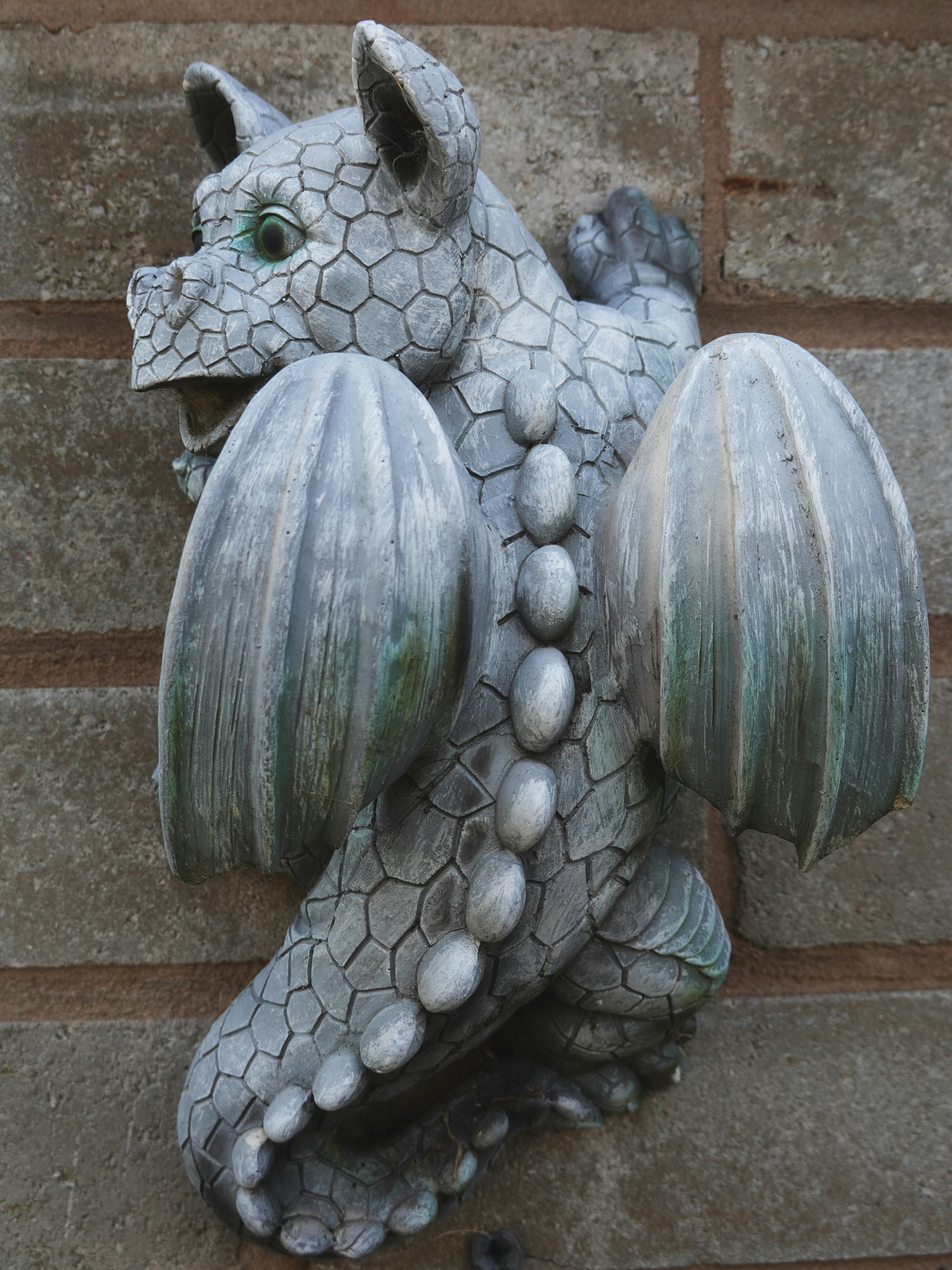 Grain-Textured Dragon Statue on Brick Wall
