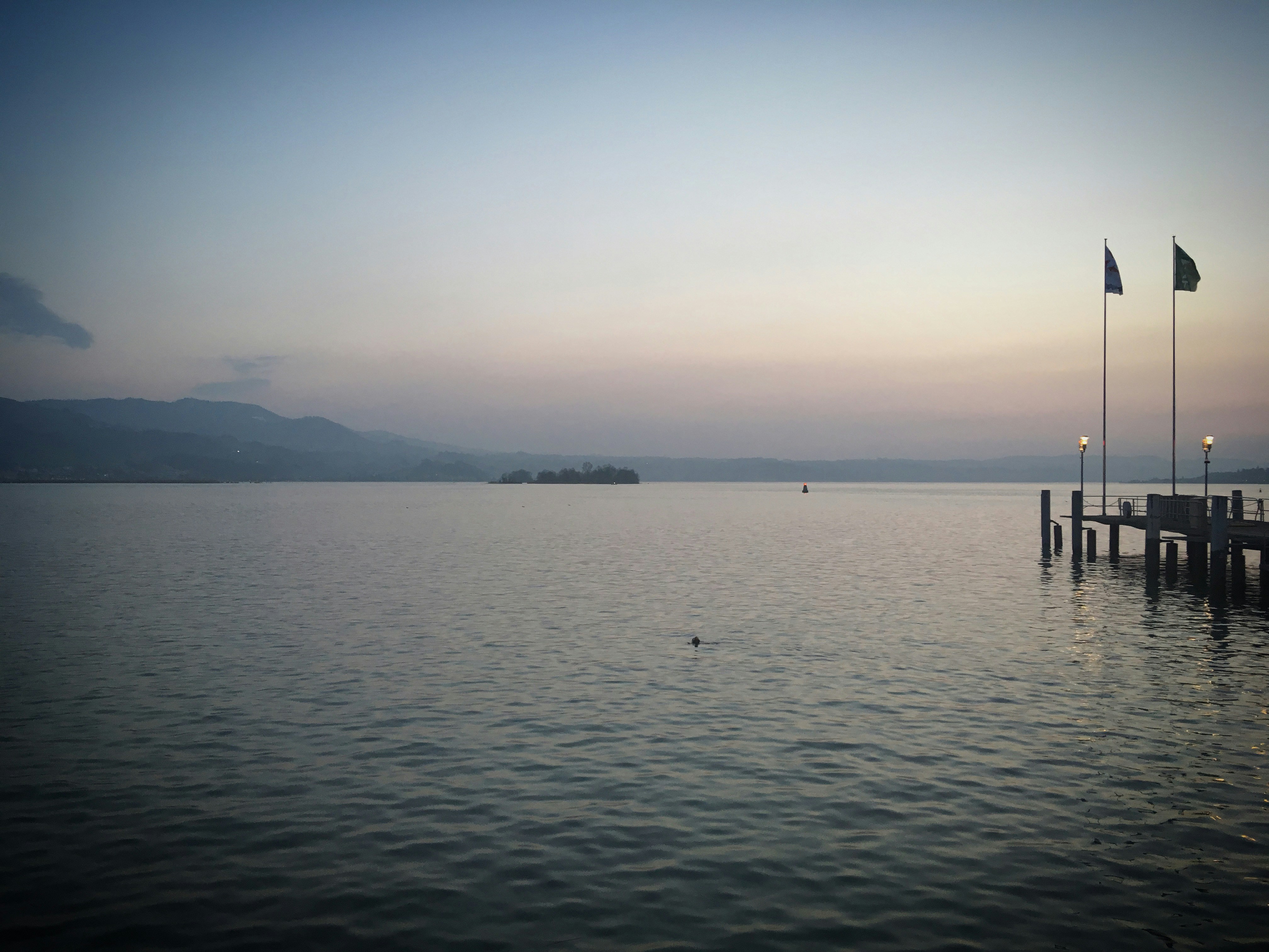 Distant Island at Dusk: Quiet Horizon Over a Serene Lake