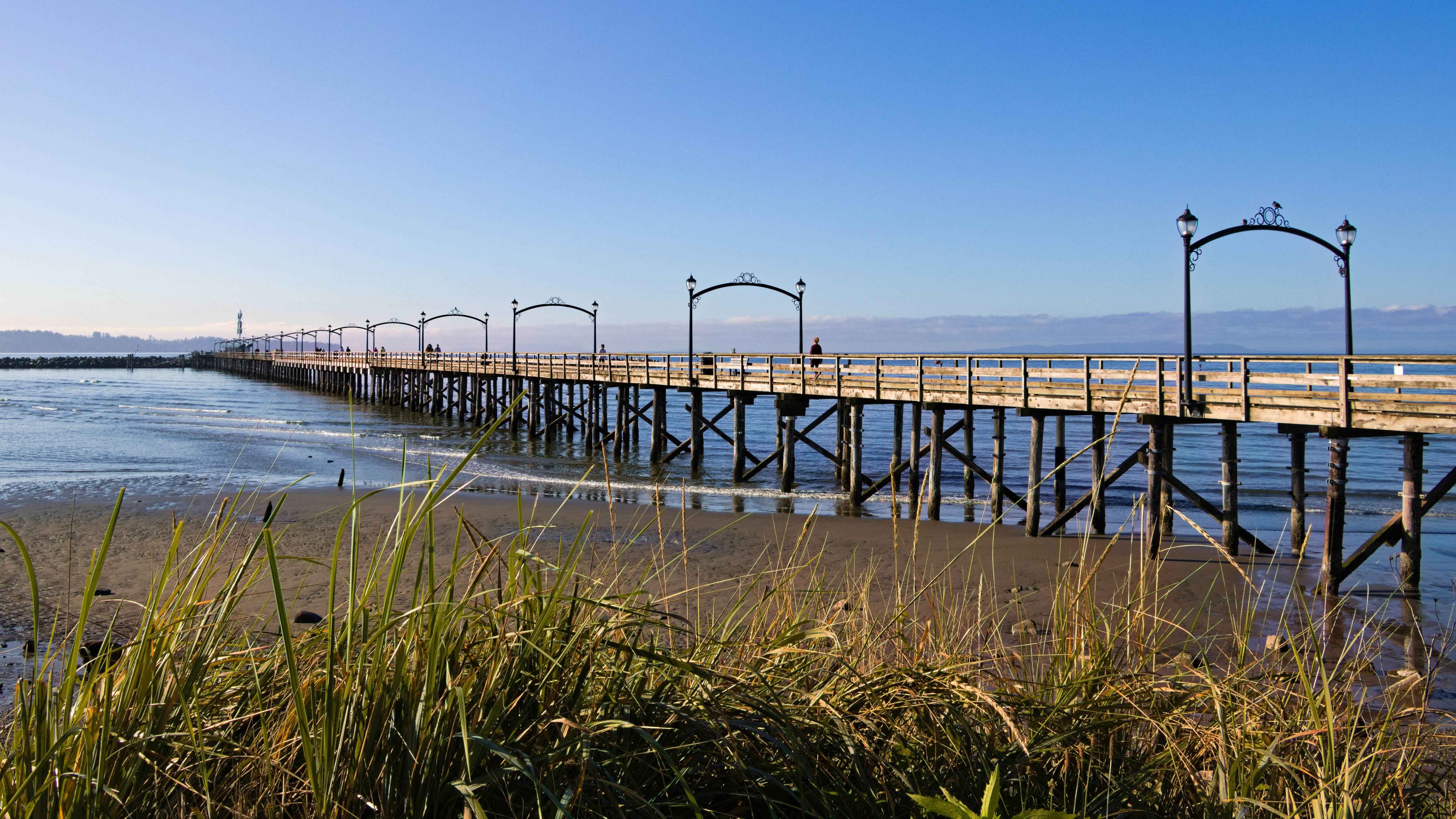 Sunlit Pier Crossing: A Quiet Seascape Under Clear Skies