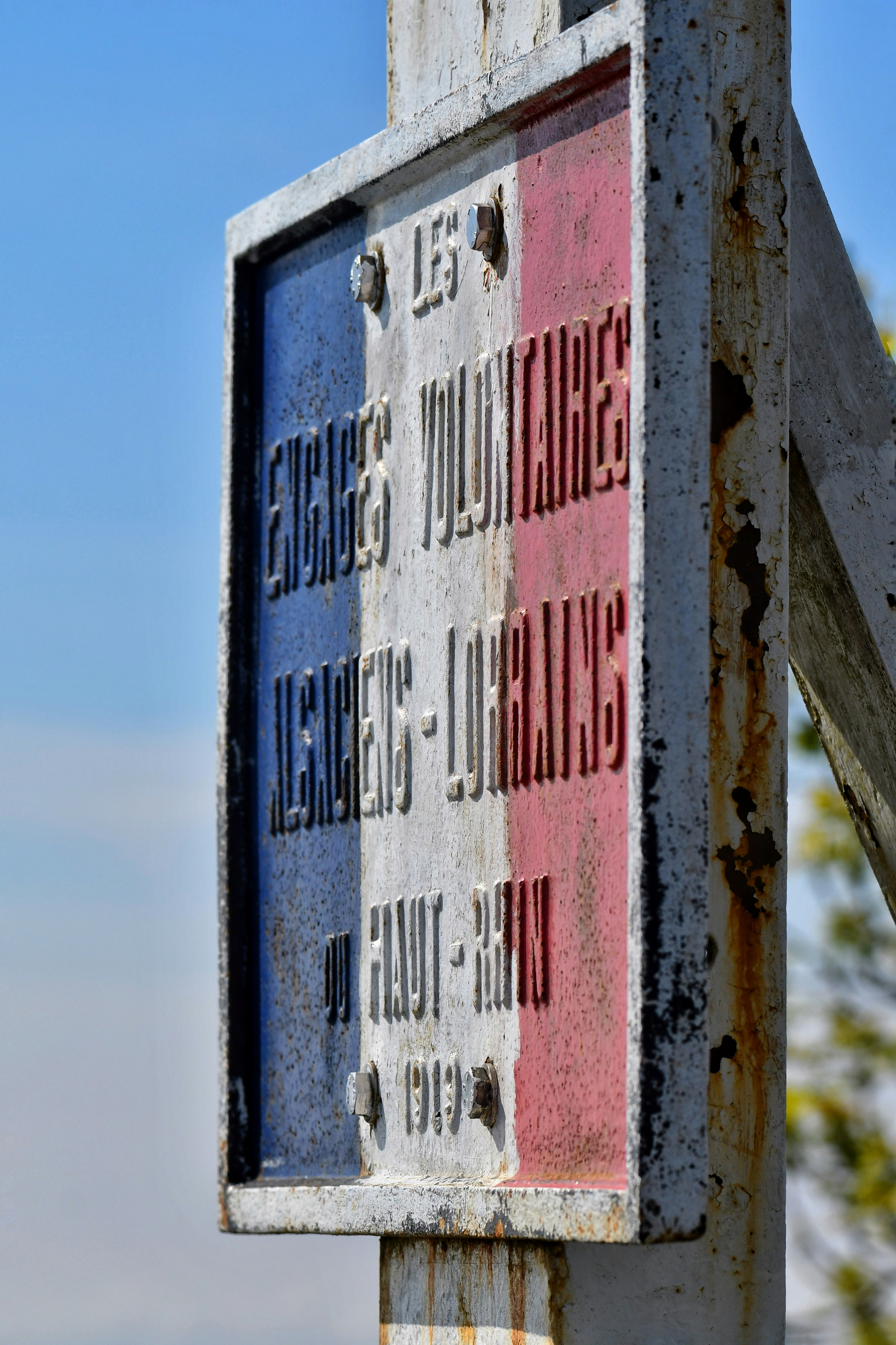 Weathered French Tricolor Sign Stood Tall Against a Clear Sky