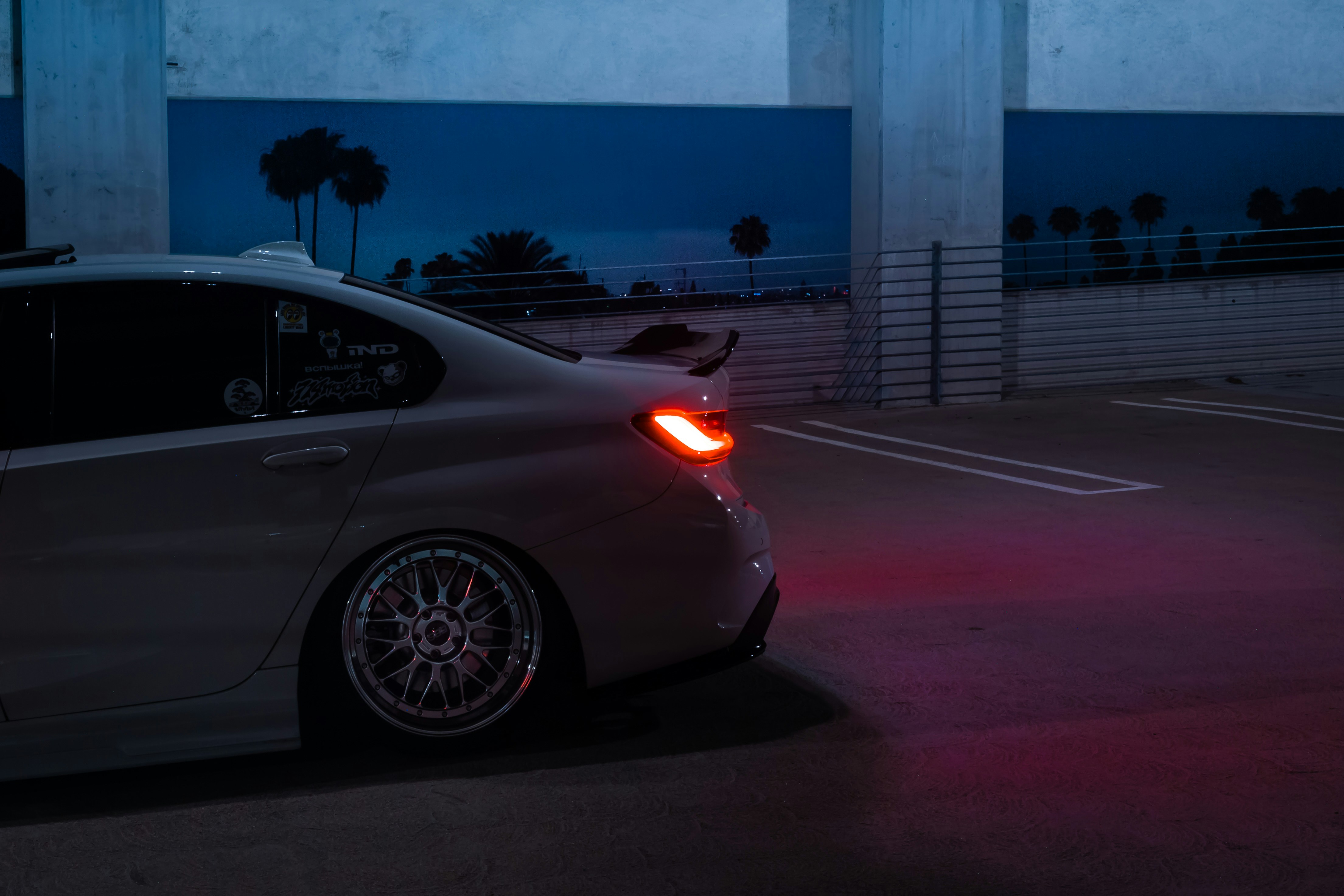 Sporty silhouette: rear quarter of a lowered sedan under dusk blue ambient